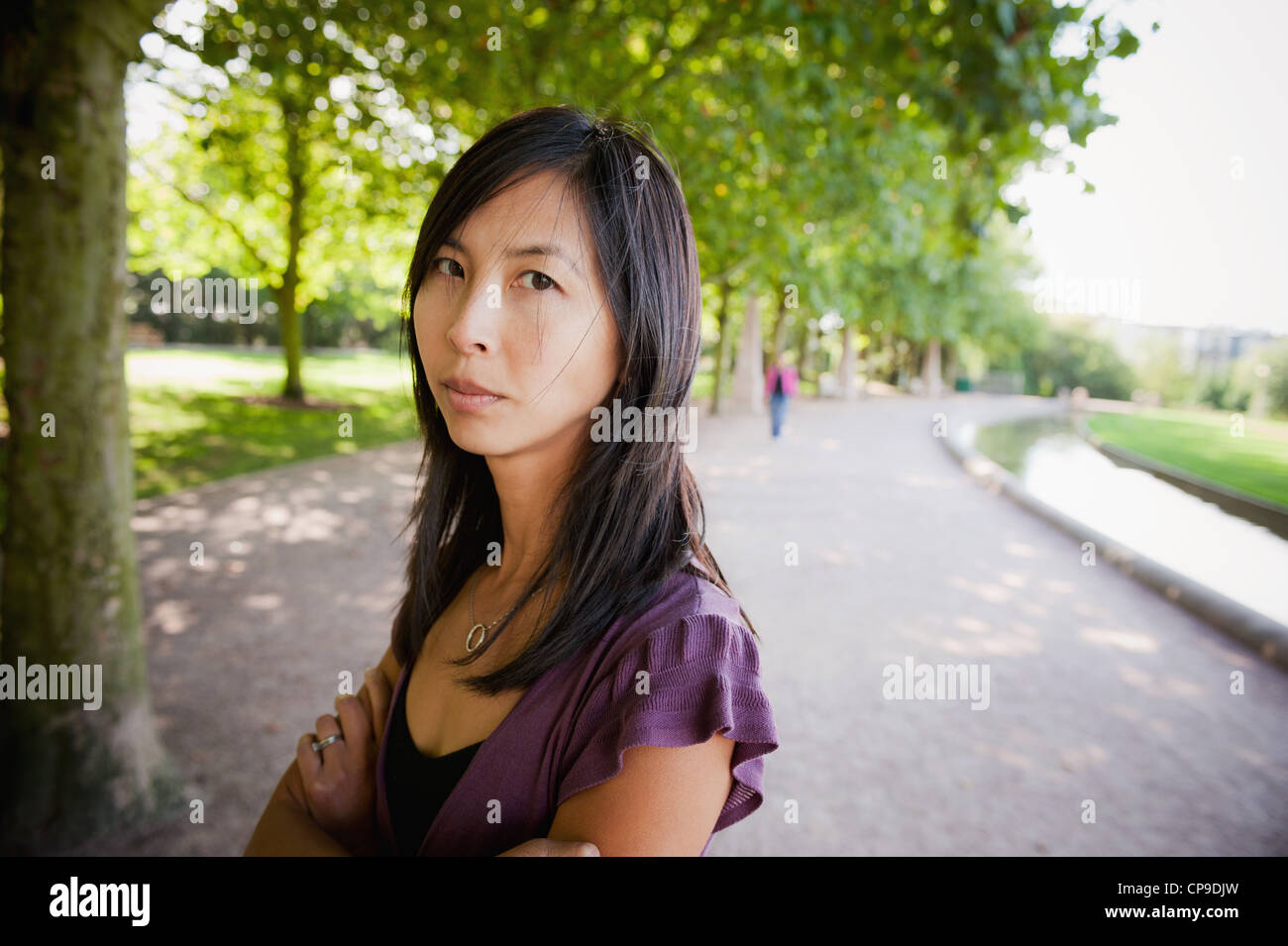 Woman looking angry in park Stock Photo - Alamy