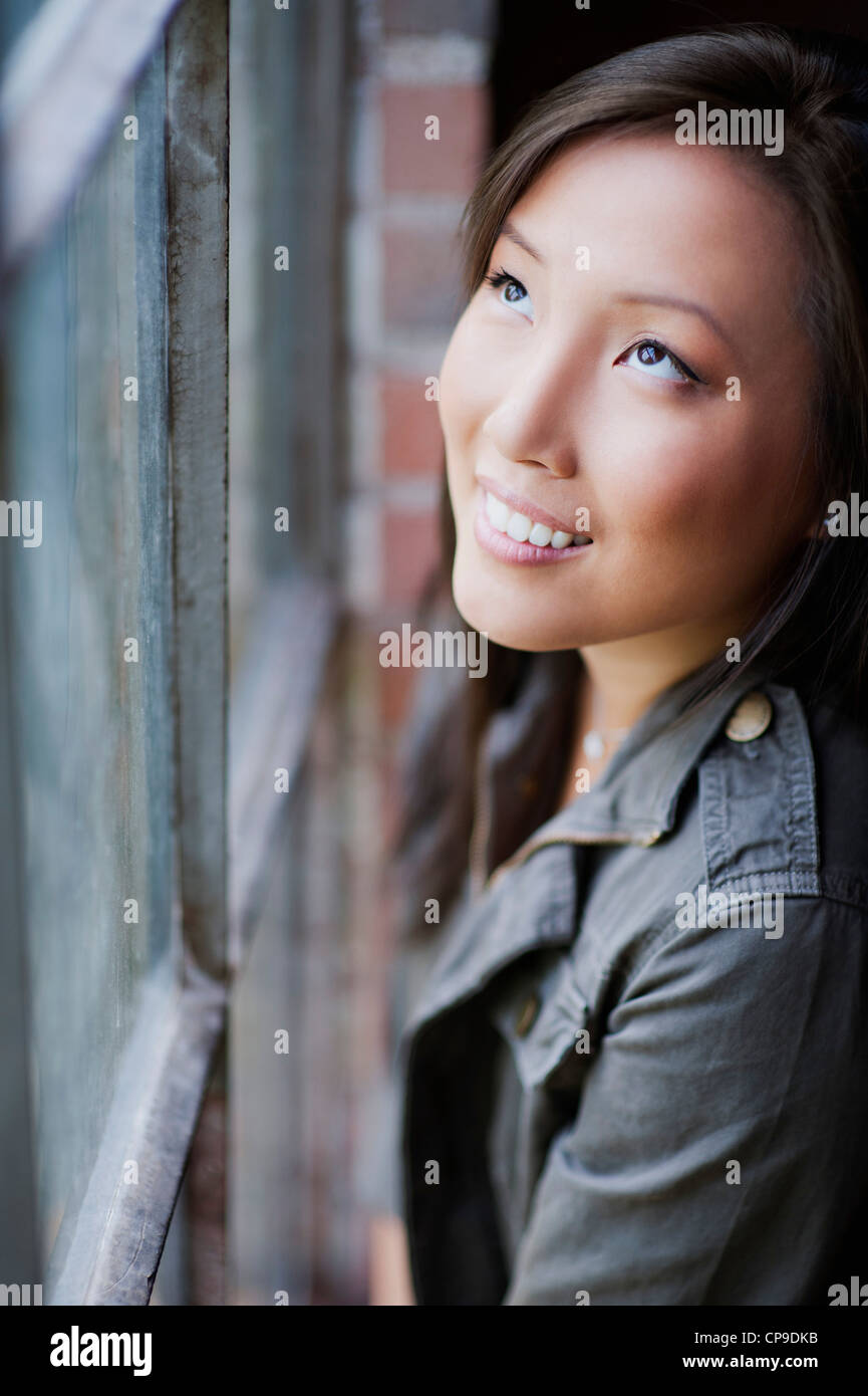 Woman looking up through a window Stock Photo - Alamy
