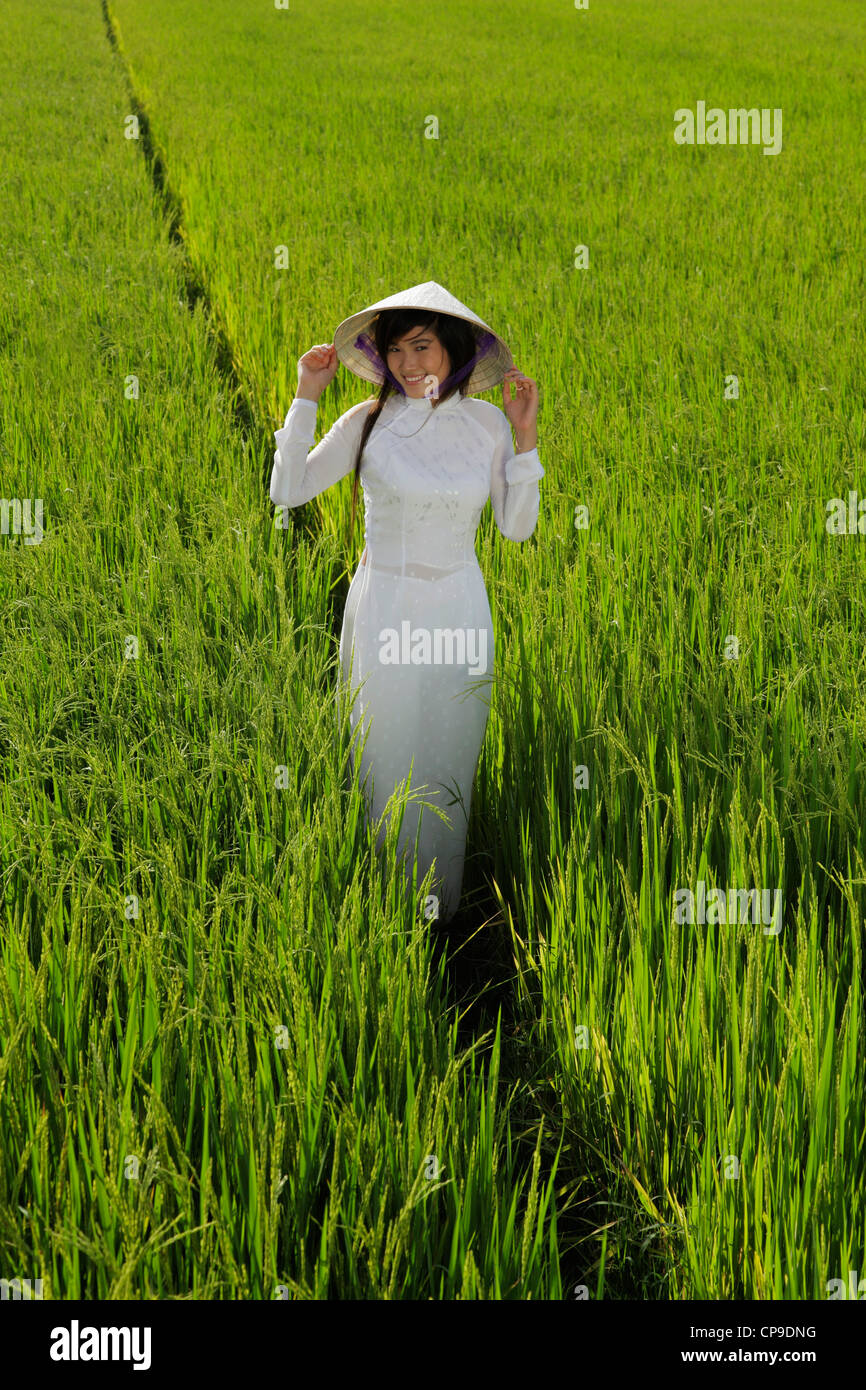 Young woman wearing traditional Vietnamese outfit standing in a rice ...