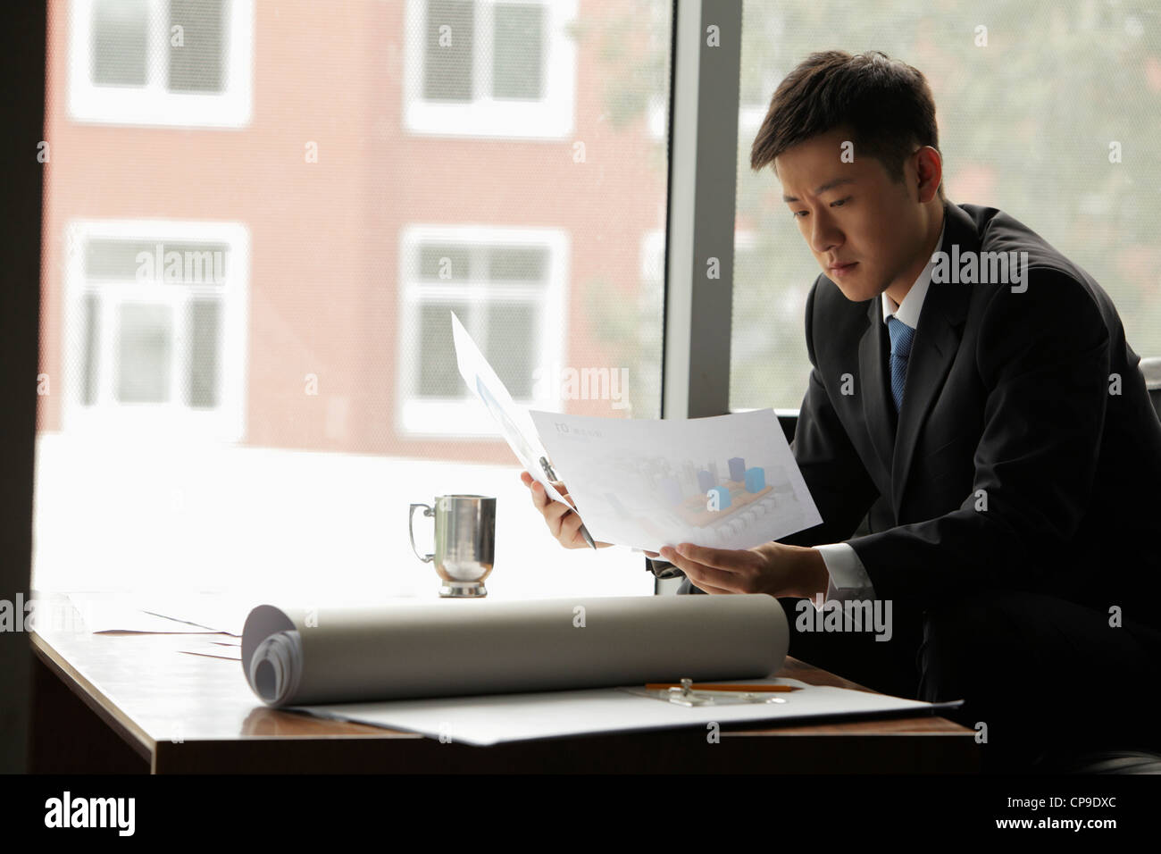 Young man working near a window in an office Stock Photo - Alamy