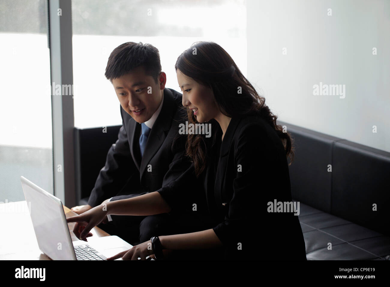 Man and women working on a laptop Stock Photo - Alamy
