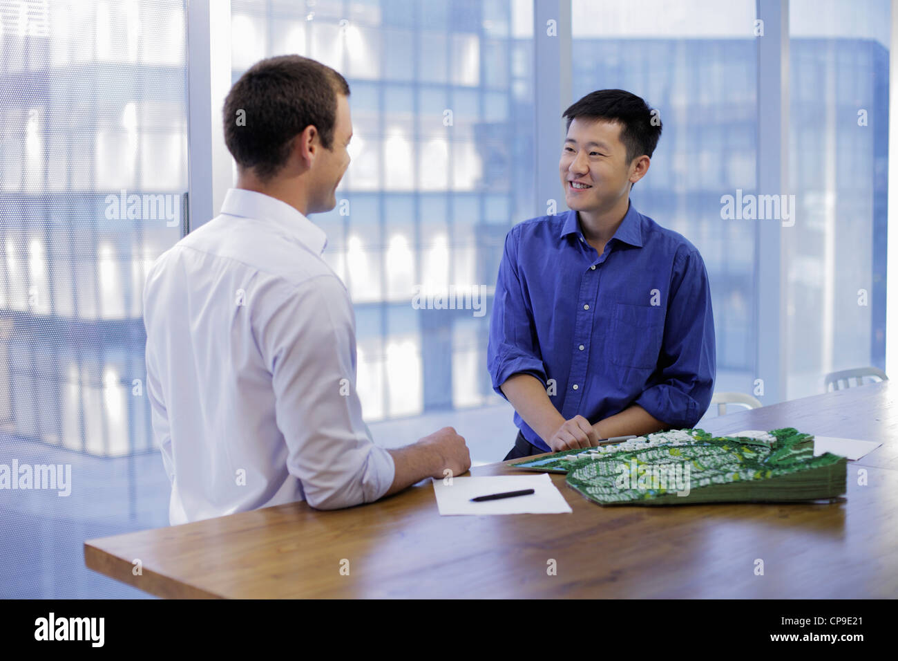 Young men talking during business meeting Stock Photo - Alamy