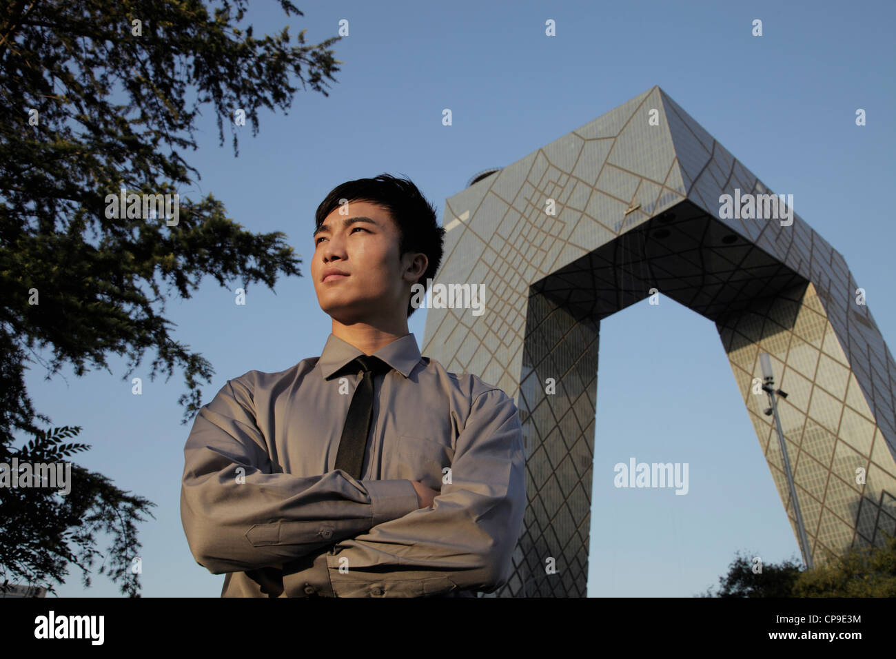 Young man standing in front of CCTV Building, Beijing, China Stock ...