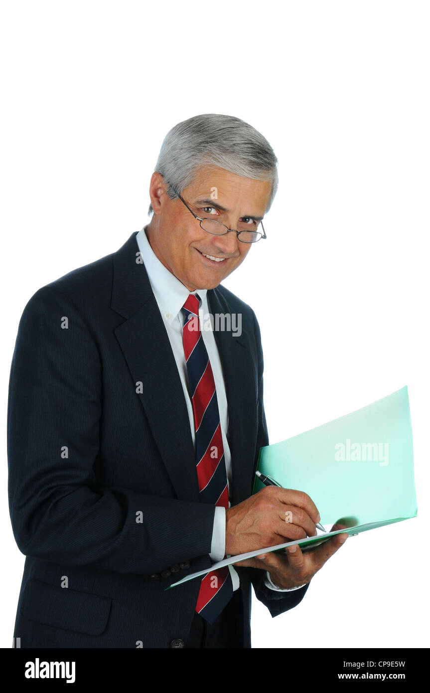 Portrait of a smiling middle aged business man writing in a file folder ...