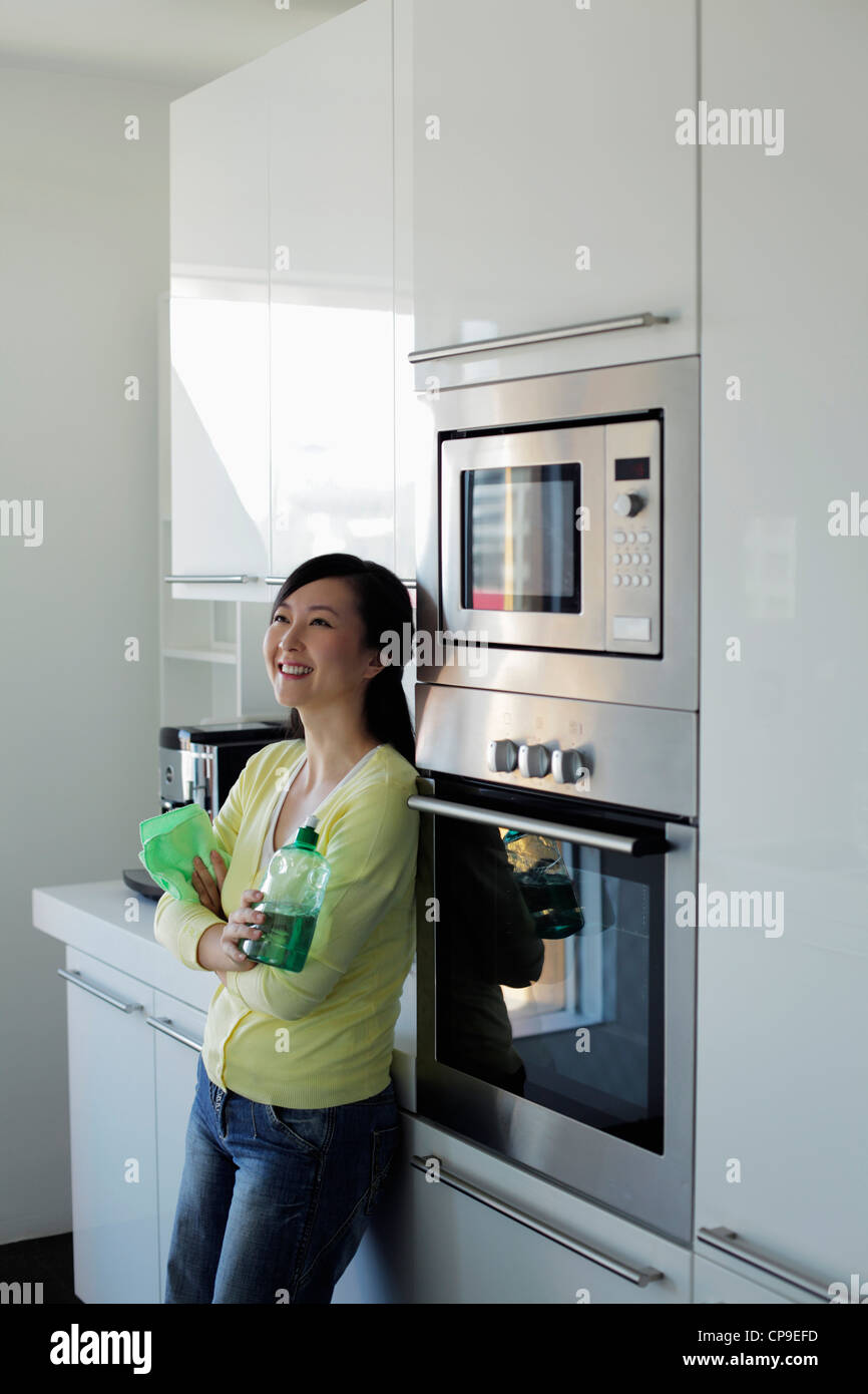 Young woman standing in kitchen looking up and smiling Stock Photo - Alamy