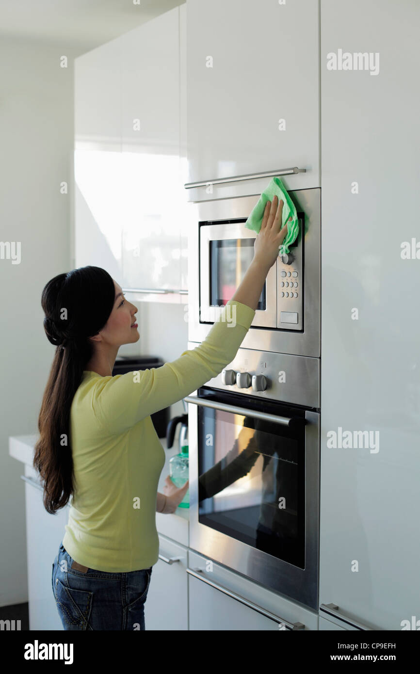 Young woman cleaning kitchen Stock Photo - Alamy