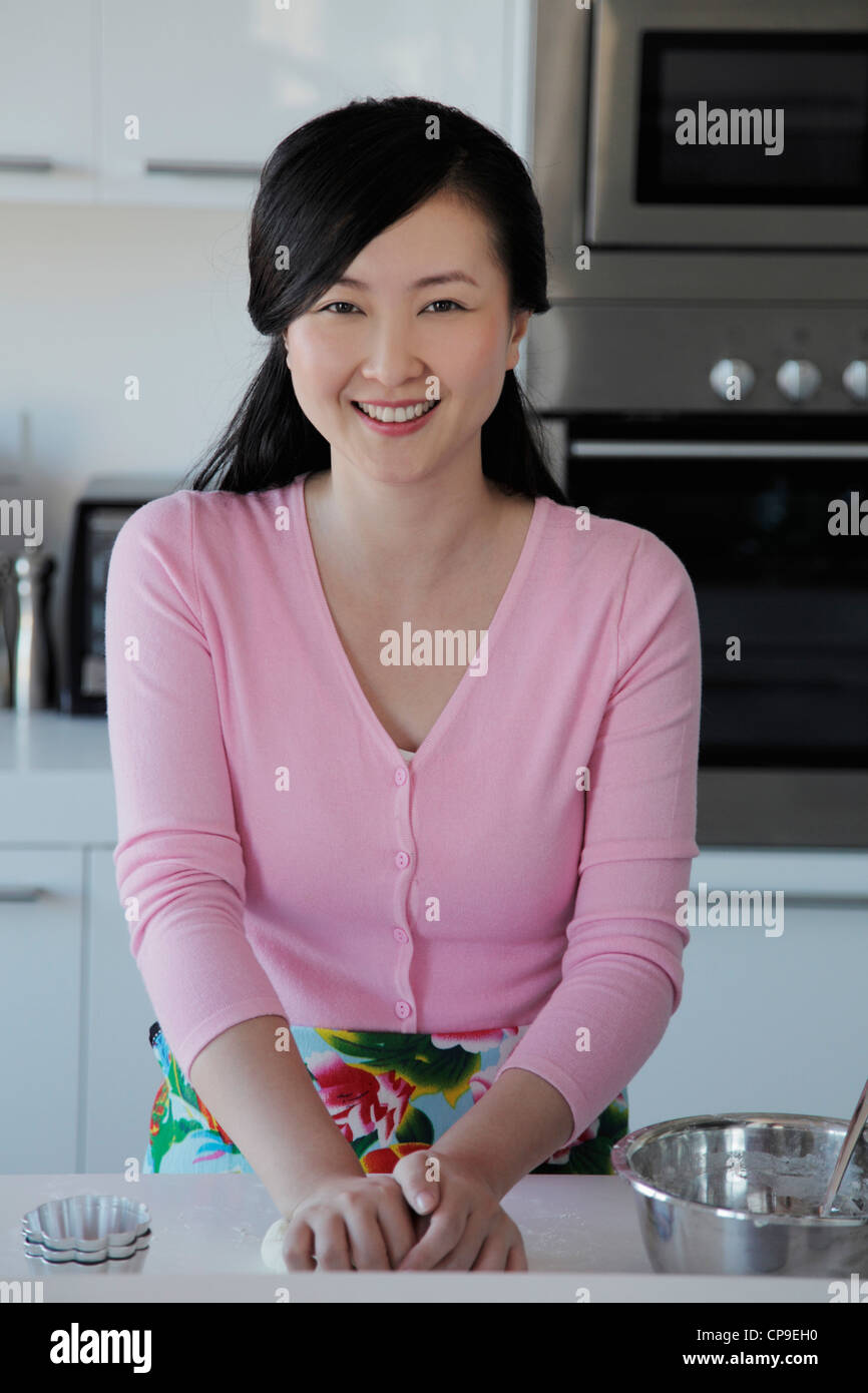 Woman cooking in kitchen and smiling Stock Photo - Alamy