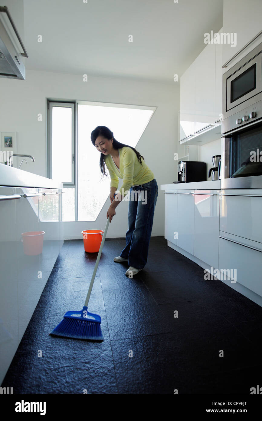 Woman sweeping her kitchen floor Stock Photo - Alamy
