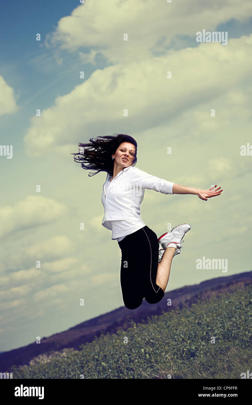 a young jumping woman in front of rural landscape Stock Photo - Alamy