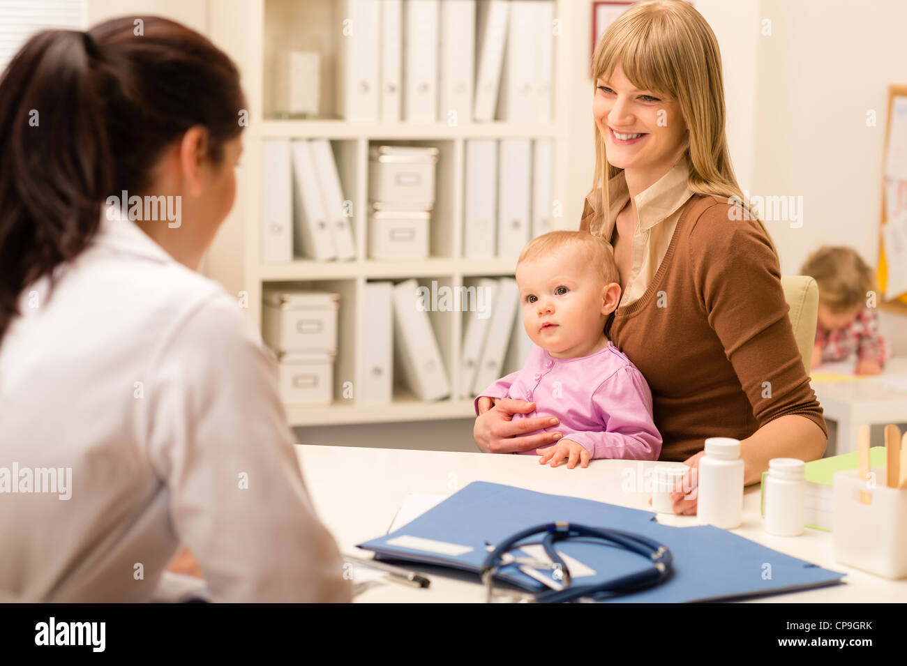 Young woman with baby girl visit pediatrician office for medical check ...