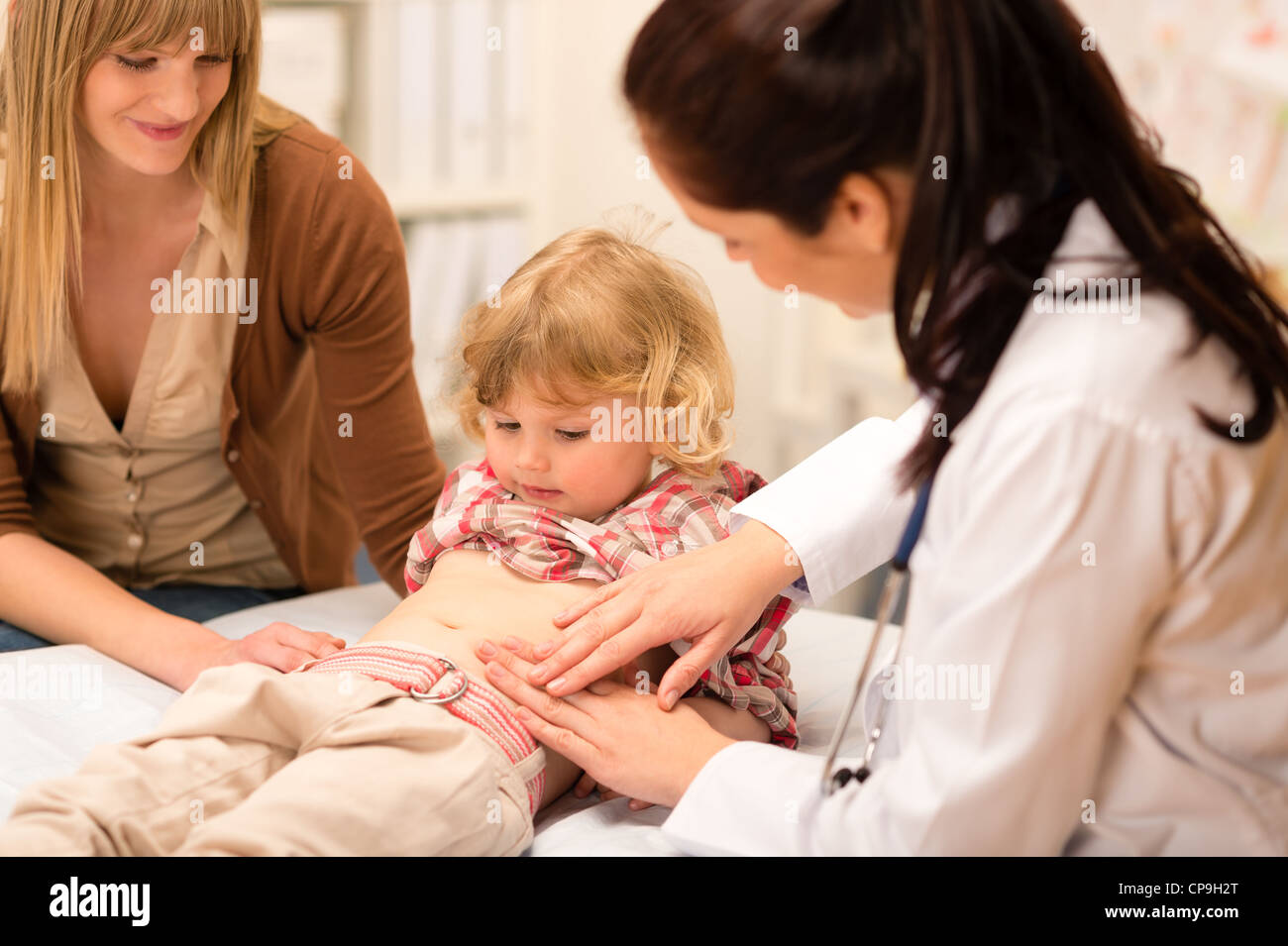 Little girl having tummy examination by pediatrician at medical office ...
