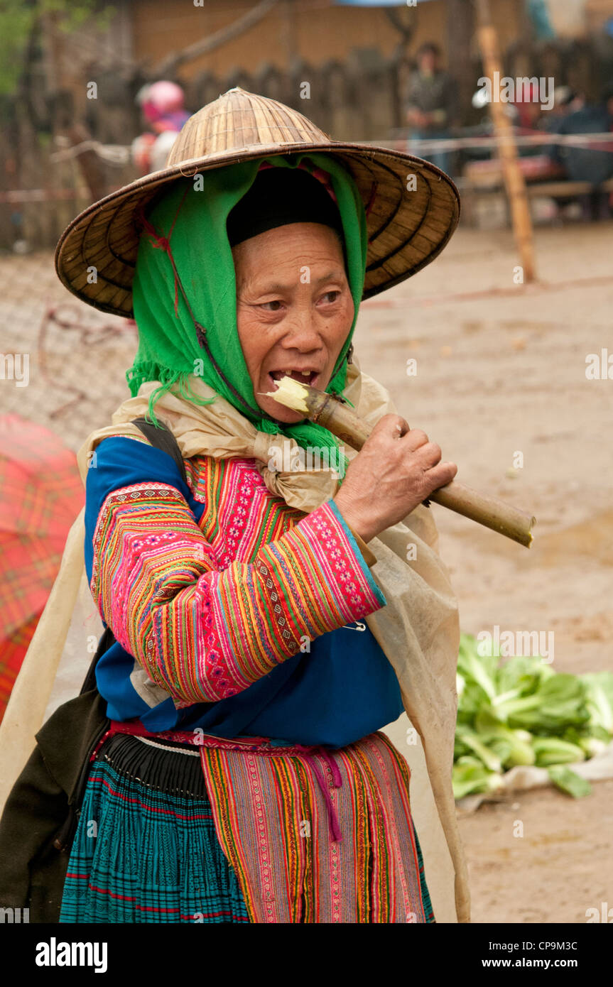 Old Flower Hmong woman eating sugar cane Muong Khuong market North ...