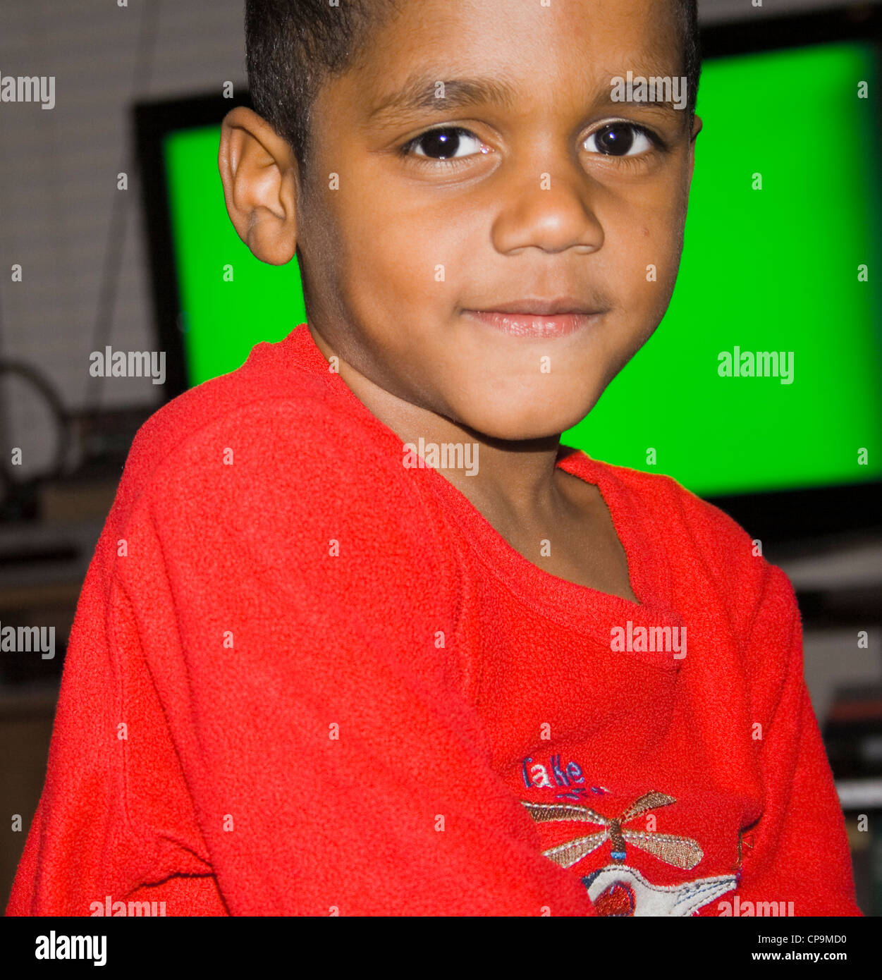 Male child smiling into camera; wearing bright tee-shirt with ...