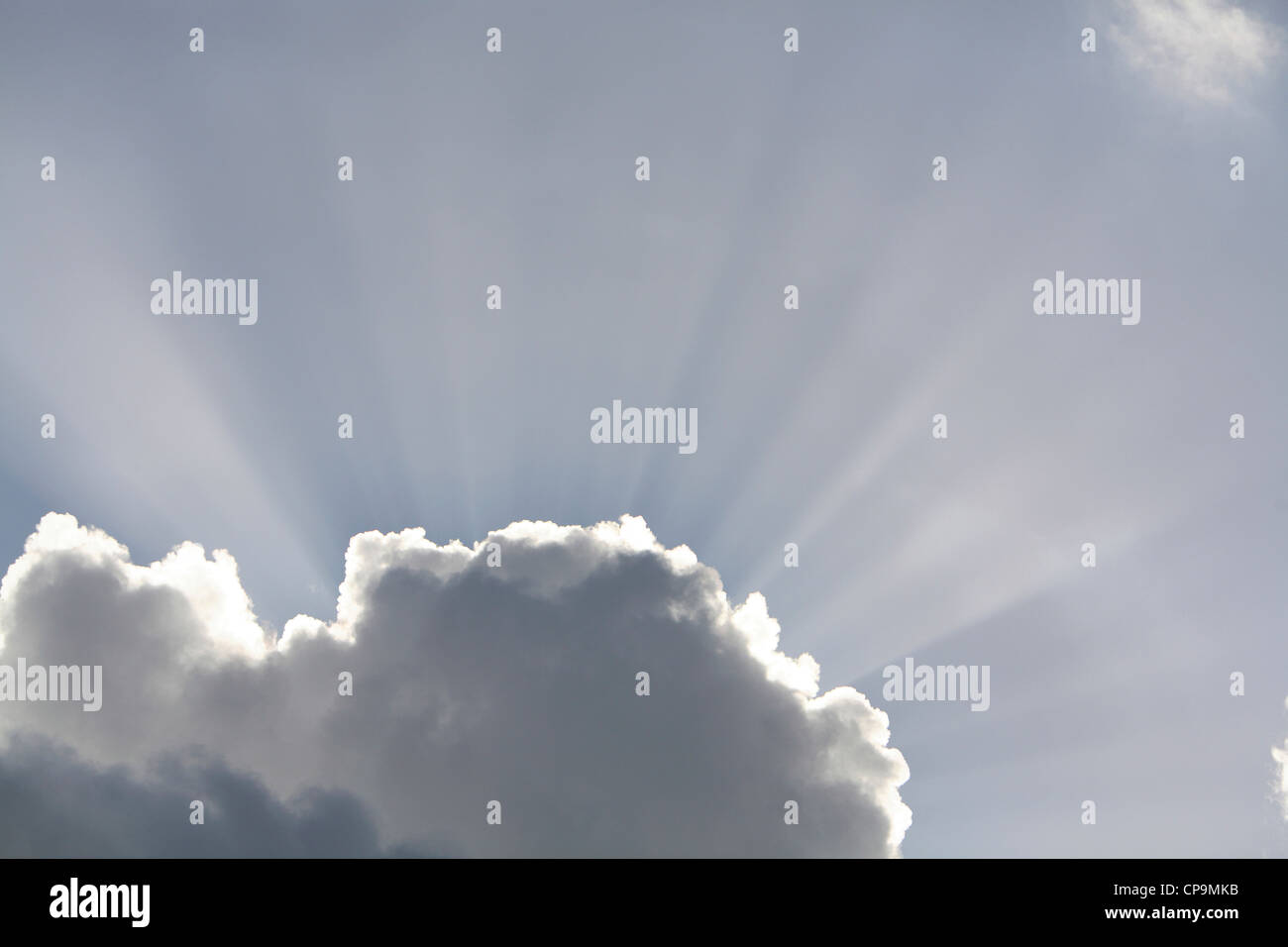 Sun shining behind clouds Stock Photo - Alamy