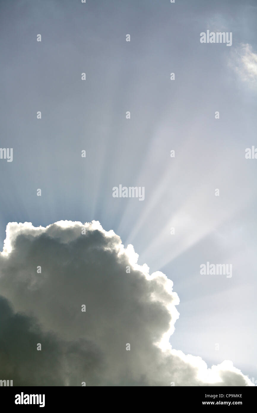 Sun shining behind clouds Stock Photo - Alamy