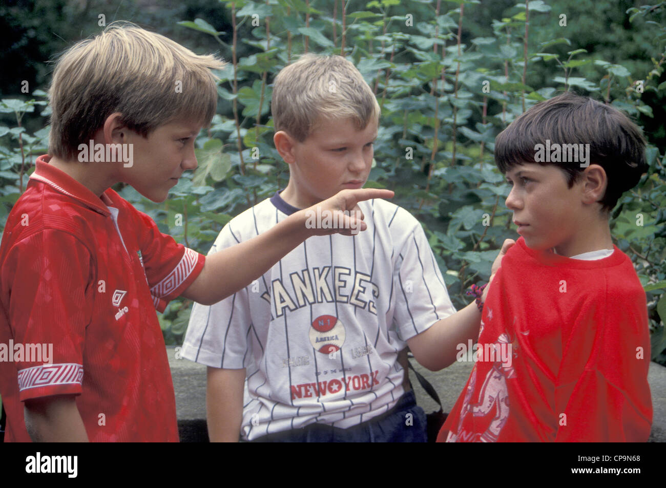 two young boys bullying a friend Stock Photo - Alamy