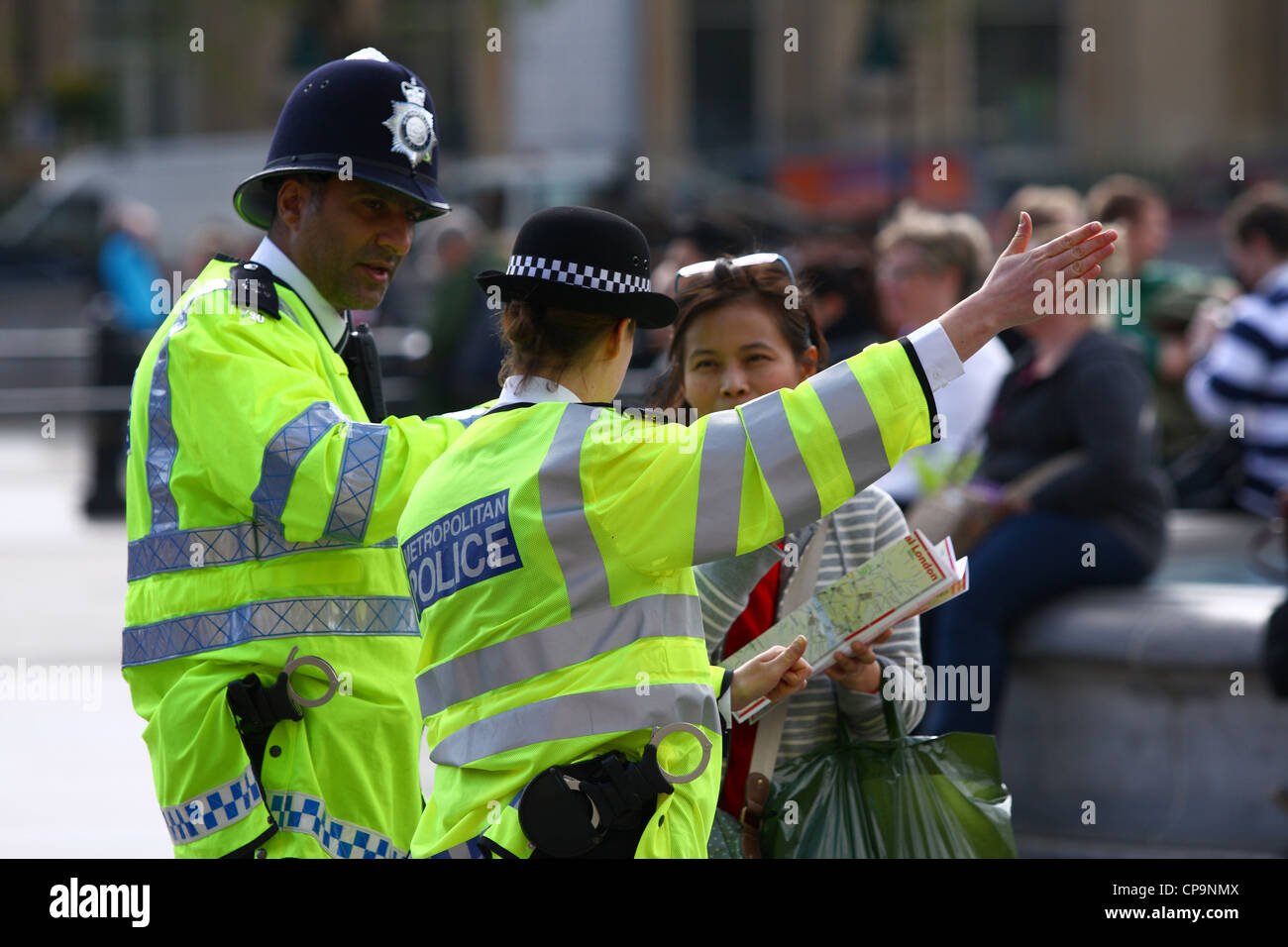 Two police giving directions to a tourist in Trafalgar Square, London ...