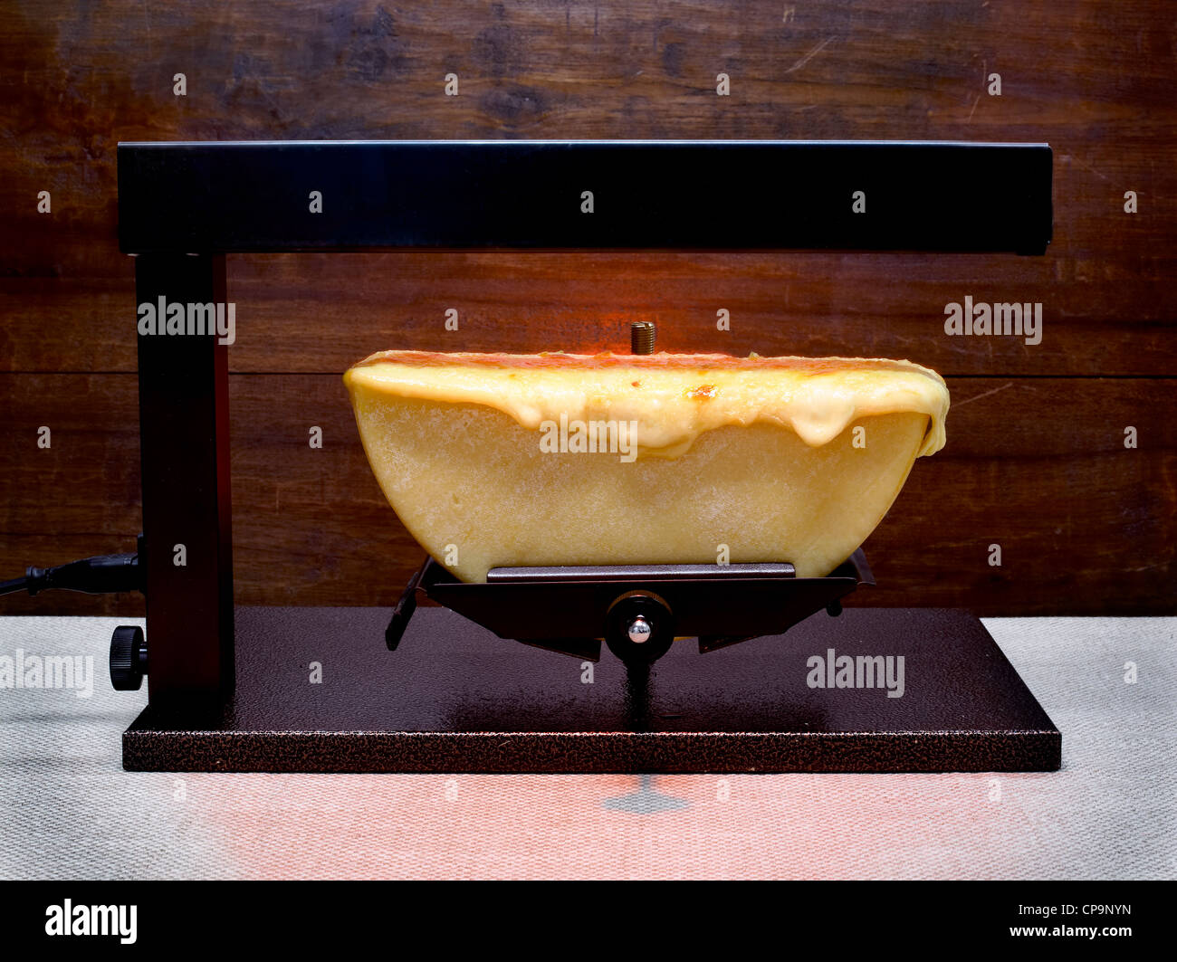 melting Raclette cheese under heater Stock Photo - Alamy