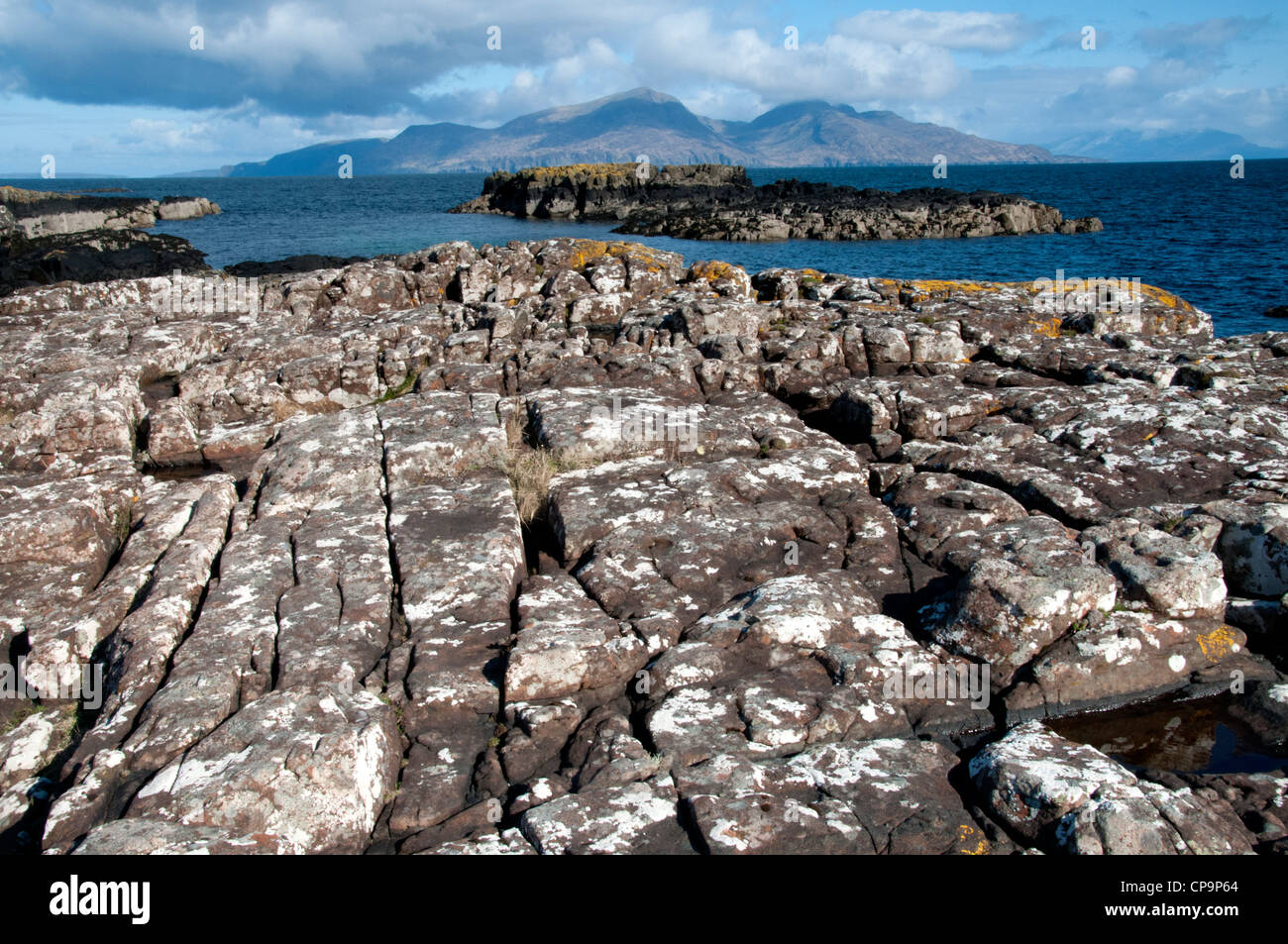 a landscape of isle of muck with isle of rum in the back ground with ...