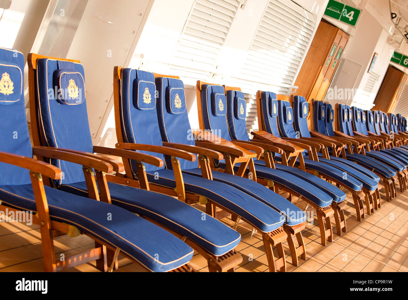 The decks of a cruise liner are lined with recliner or steam chairs for ...
