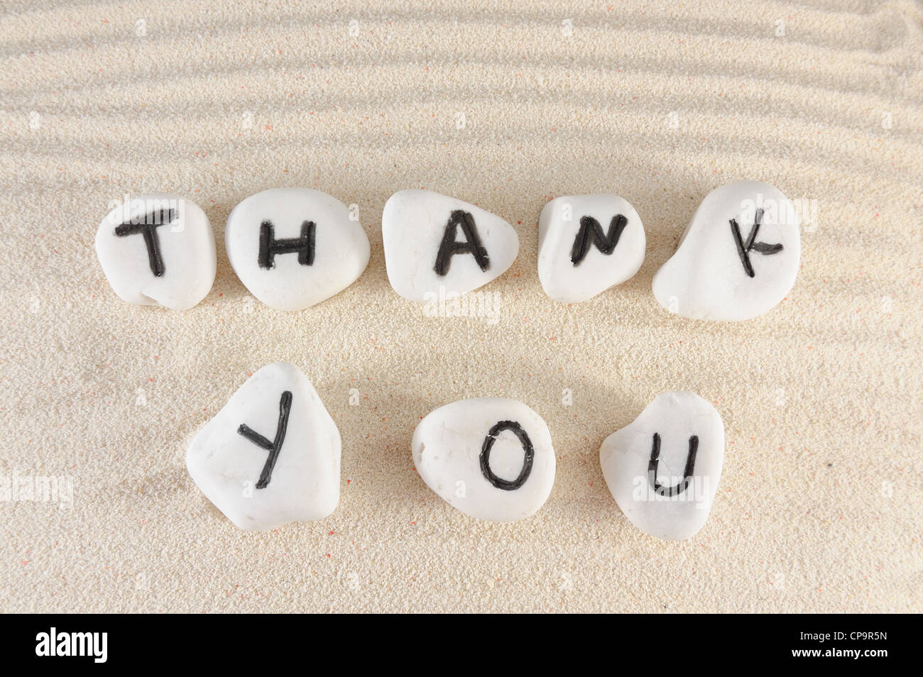 Thank you words on group of stones with sand as background Stock Photo ...