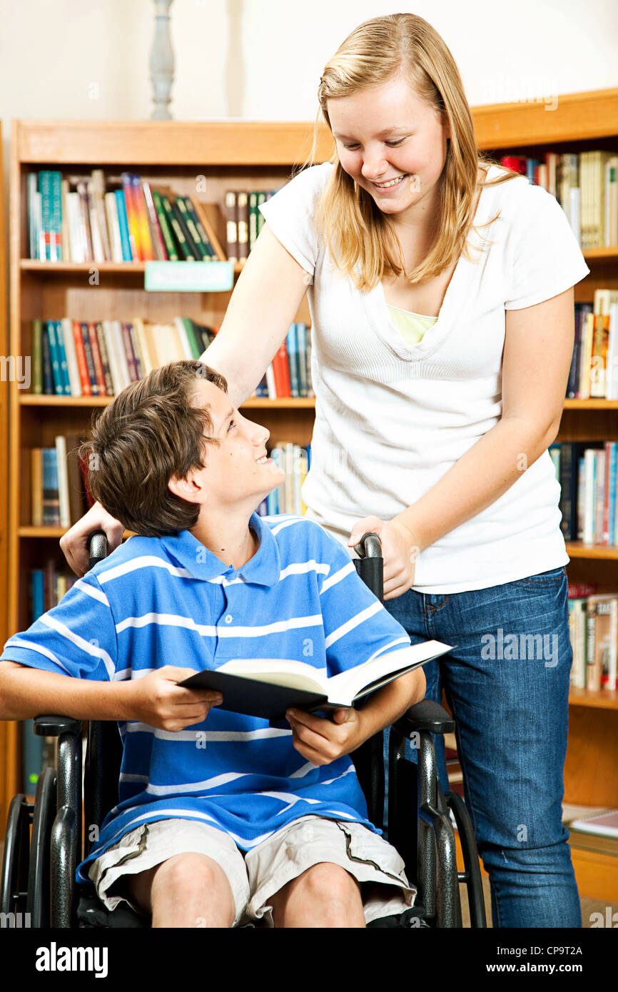 Teen girl and disabled boy in the school library Stock Photo - Alamy