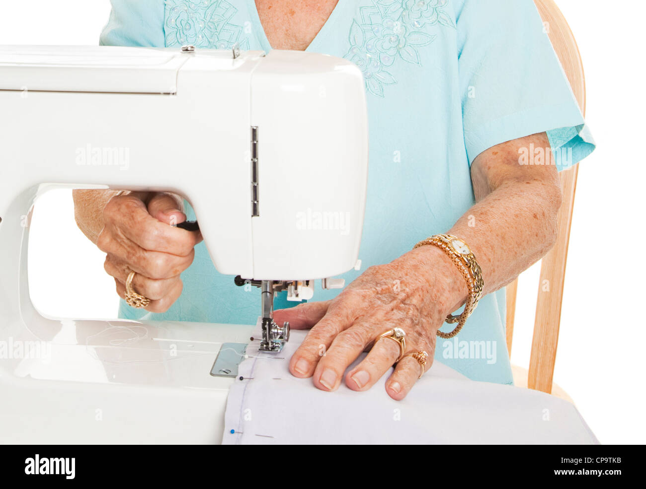 Senior woman's hands using her sewing machine. White Background Stock ...