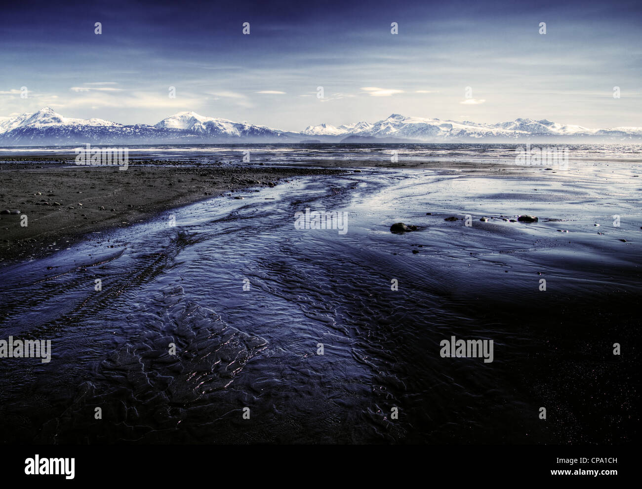 Alaskan beach near Homer at low tide with water flowing to the sea and ...