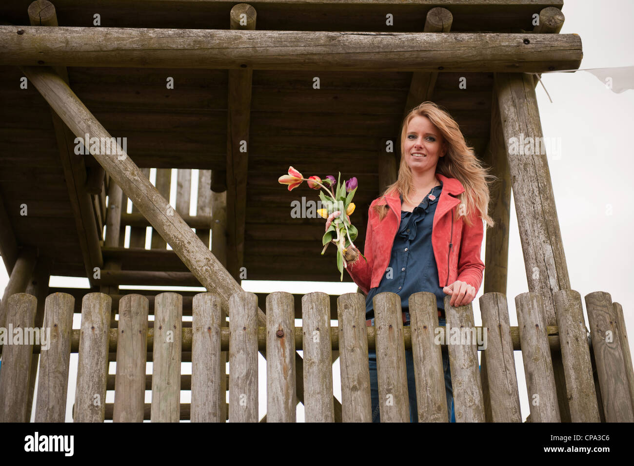 Young woman with bouquet flowers in wooden observation post Stock Photo ...
