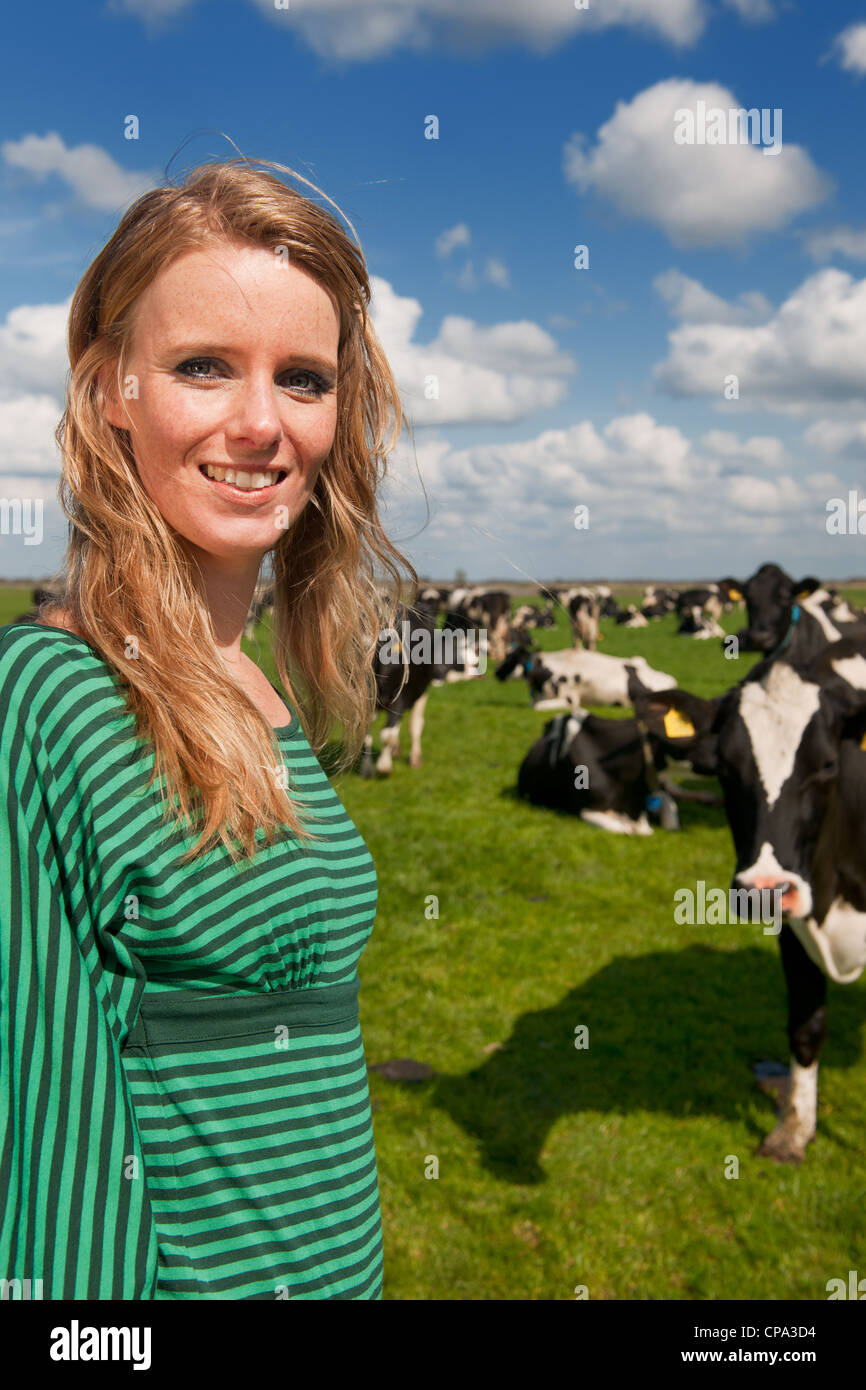 Young blond Dutch girl in farm field with black and white cows Stock ...