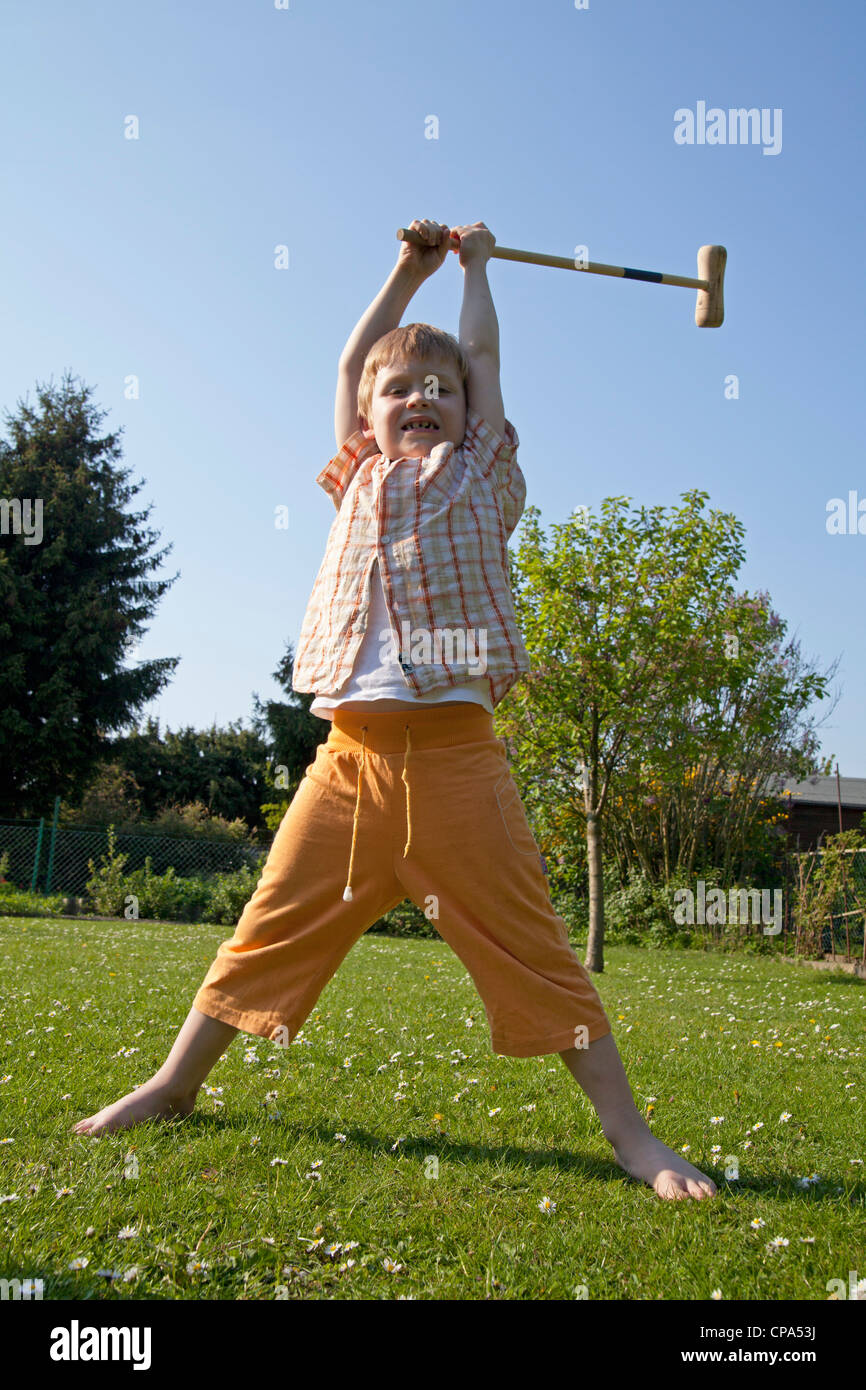 young boy hitting with a mallet Stock Photo - Alamy