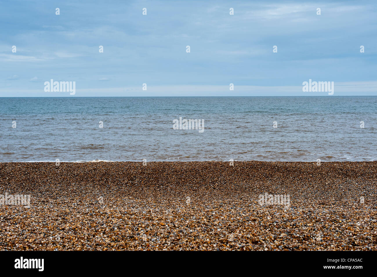 Empty shingle beach on East coast of UK. THree way split of sky sea and ...