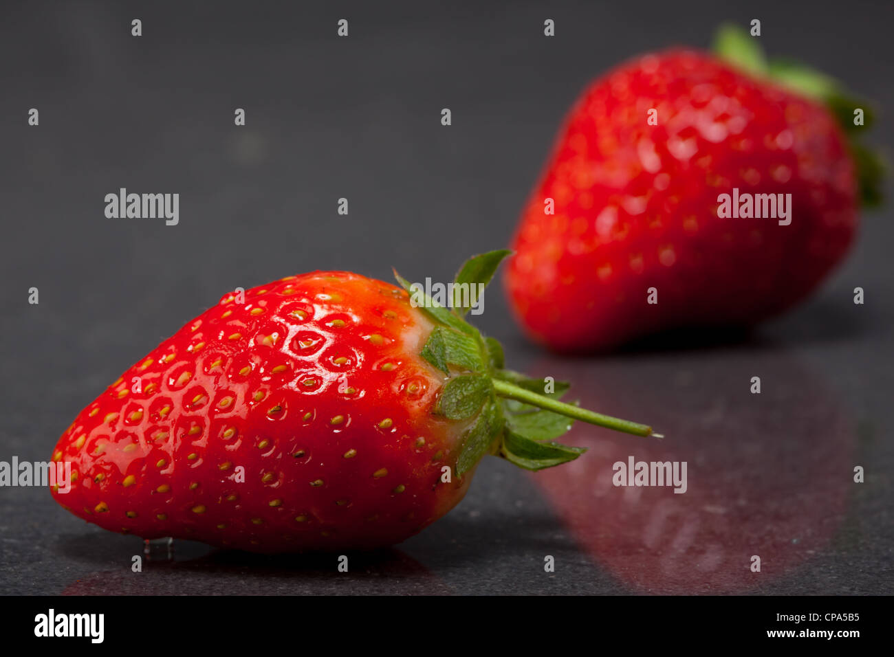 Two juicy red strawberry's on polished granite worktop Stock Photo - Alamy