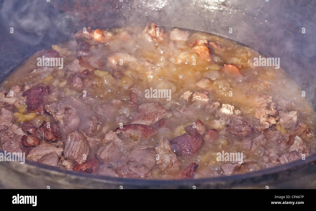 meat for pilaf prepares in a big cauldron Stock Photo - Alamy