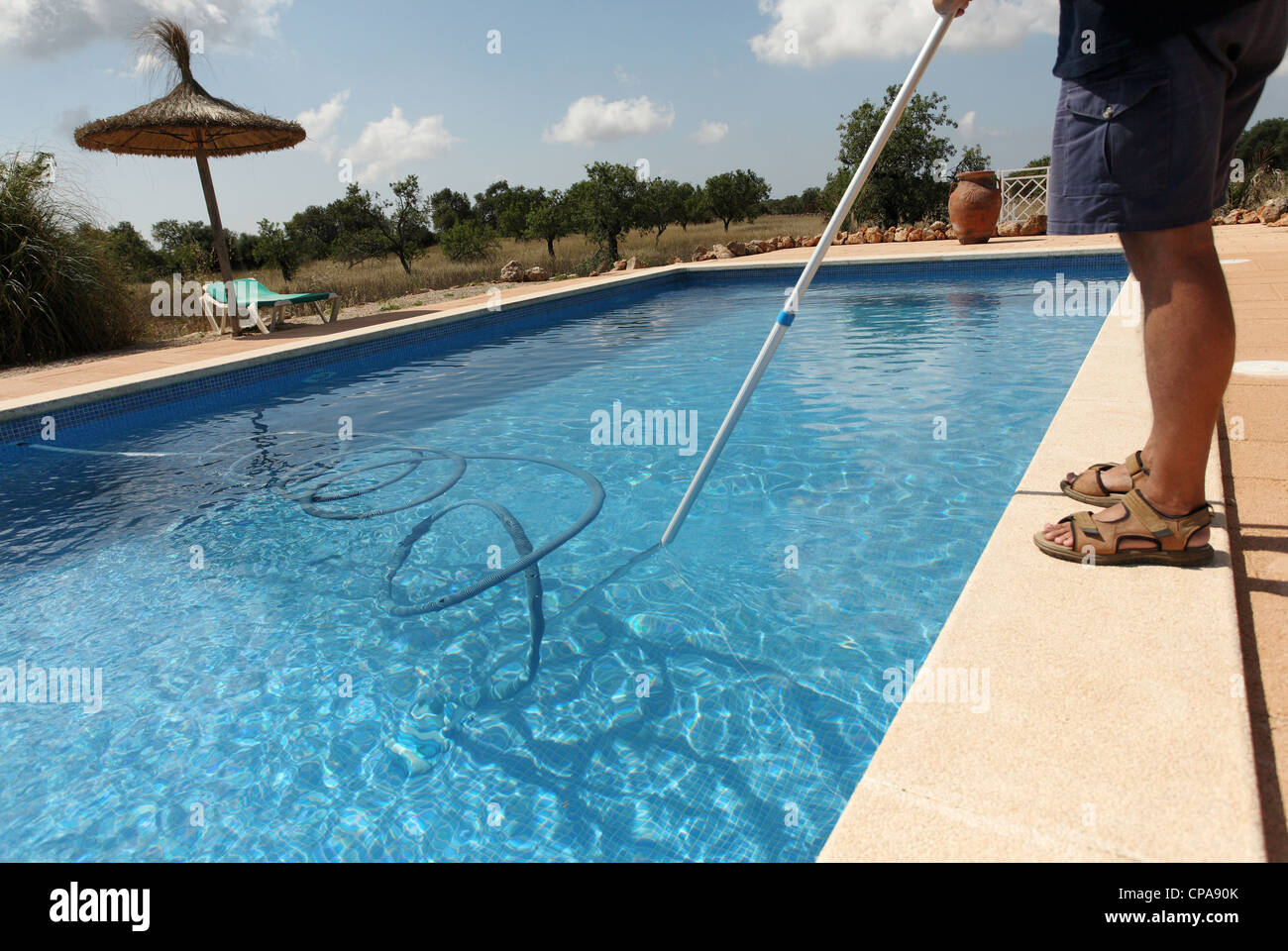Service employee cleaning a swimming pool, Llucmajor, Spain Stock Photo ...