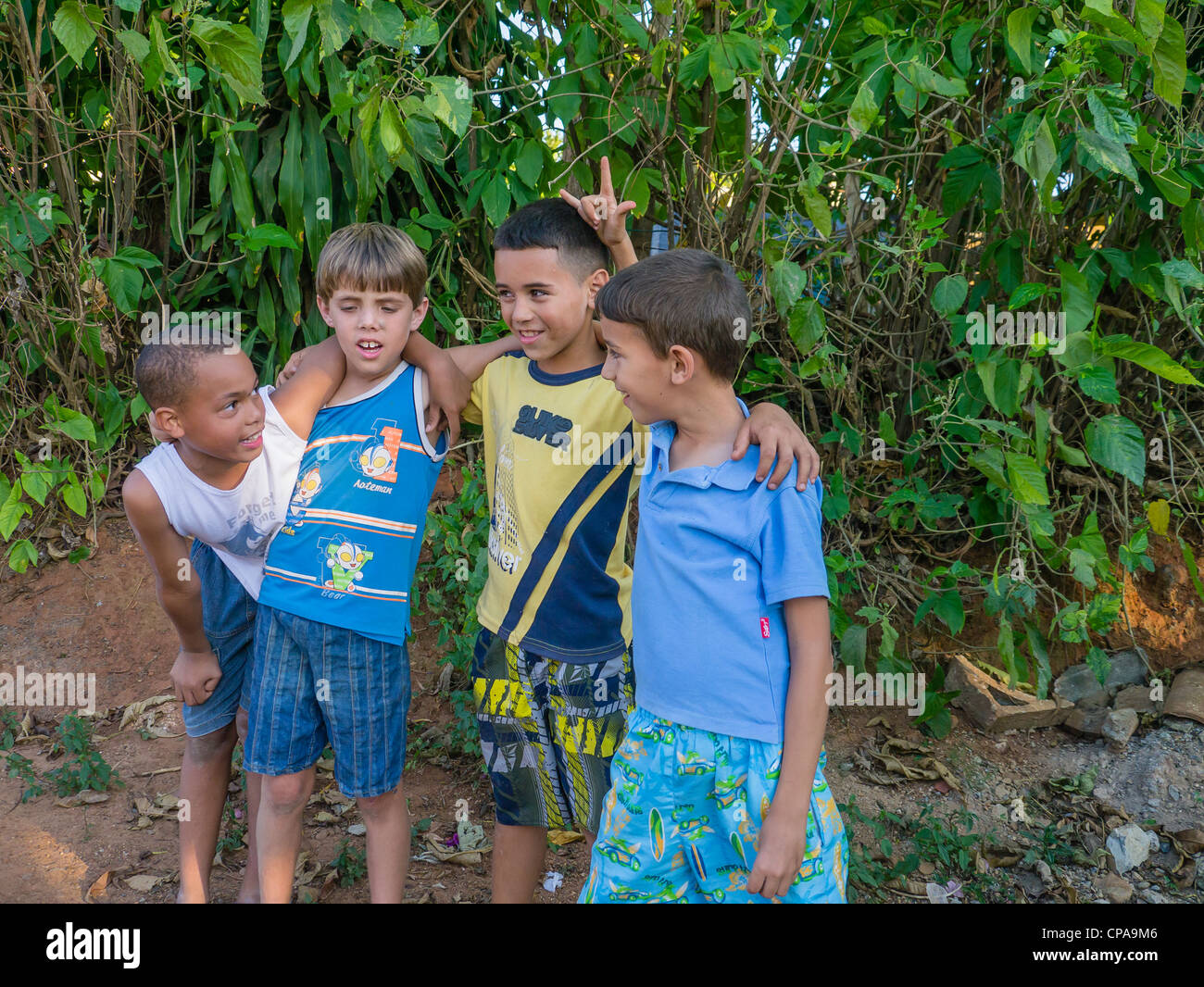 Four 10-12 year old Cuban boys play around smiling, laughing and ...
