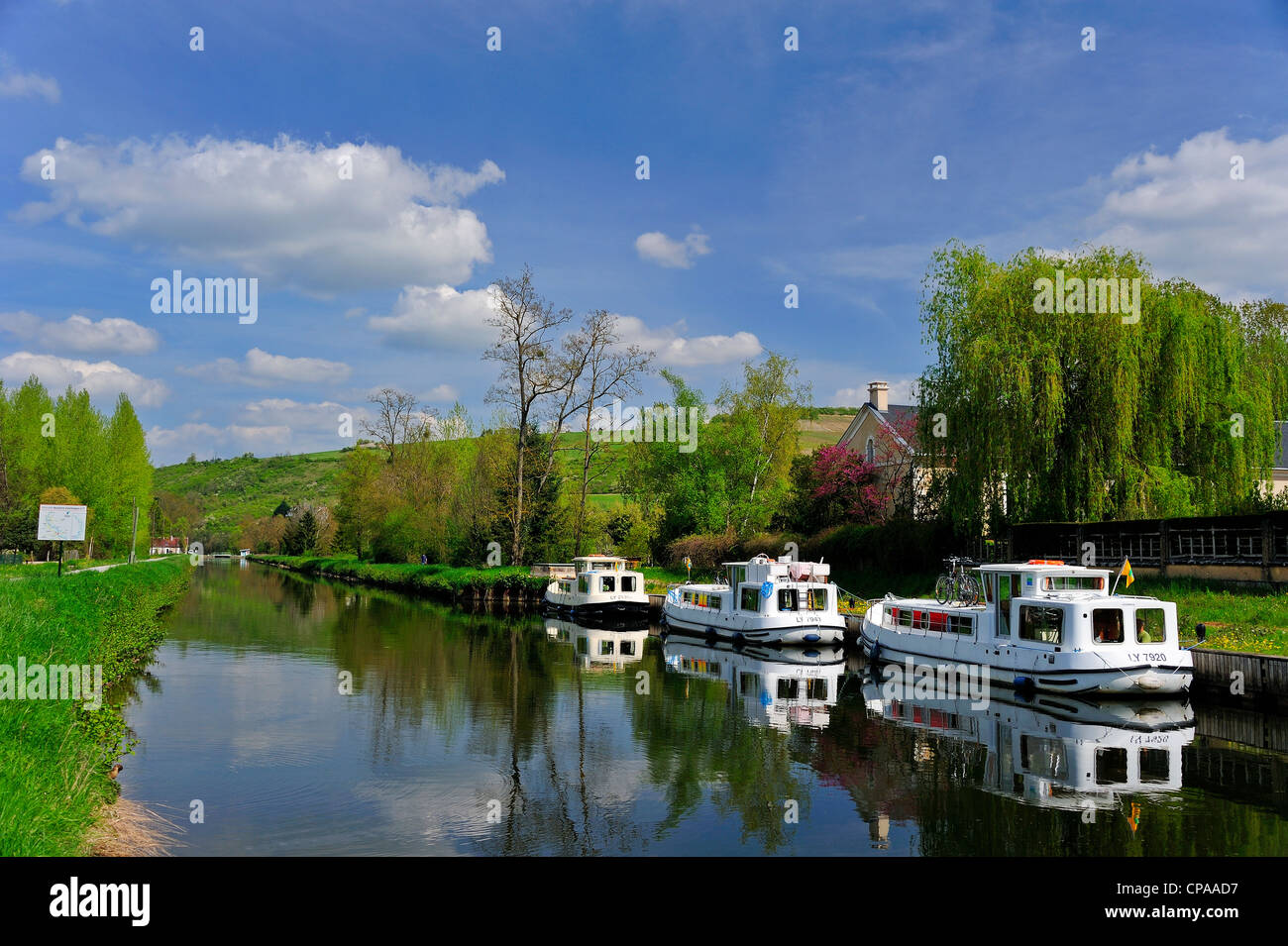 Three canal barges moored on on the Yonne River, Canal du Nivernais ...