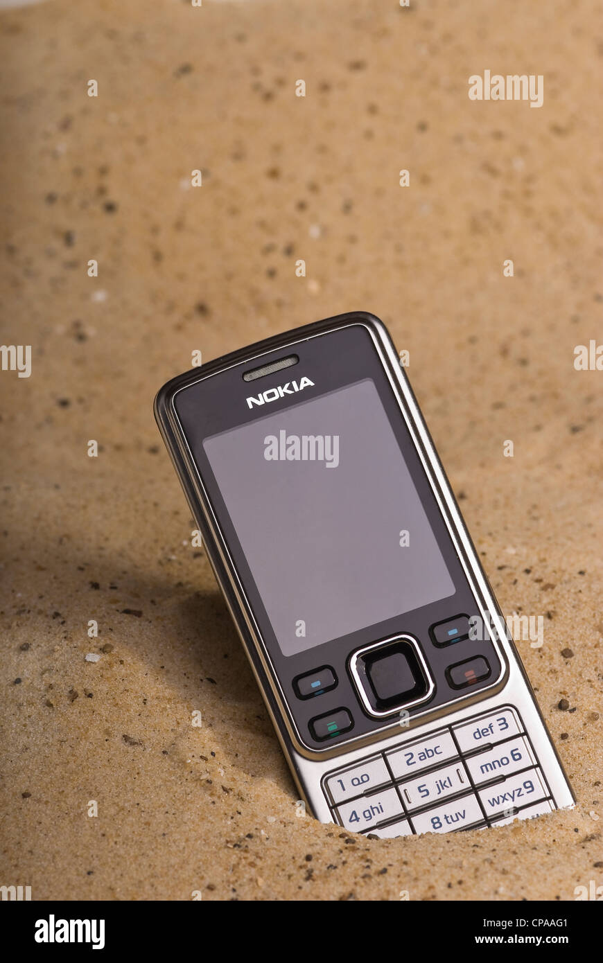 Mobile phone dropped and laying in the sand at a beach. Lost misplaced ...