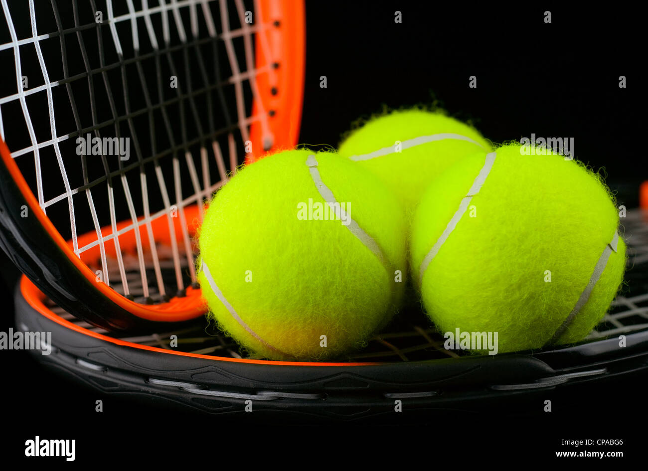 Three tennis-ball and two racket on black background Stock Photo - Alamy