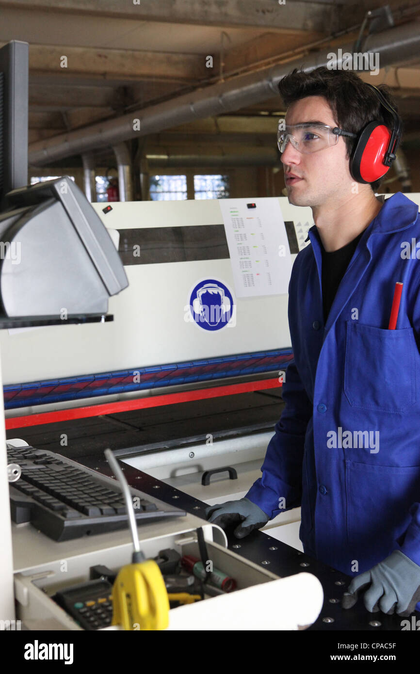 Factory worker operating machine Stock Photo - Alamy