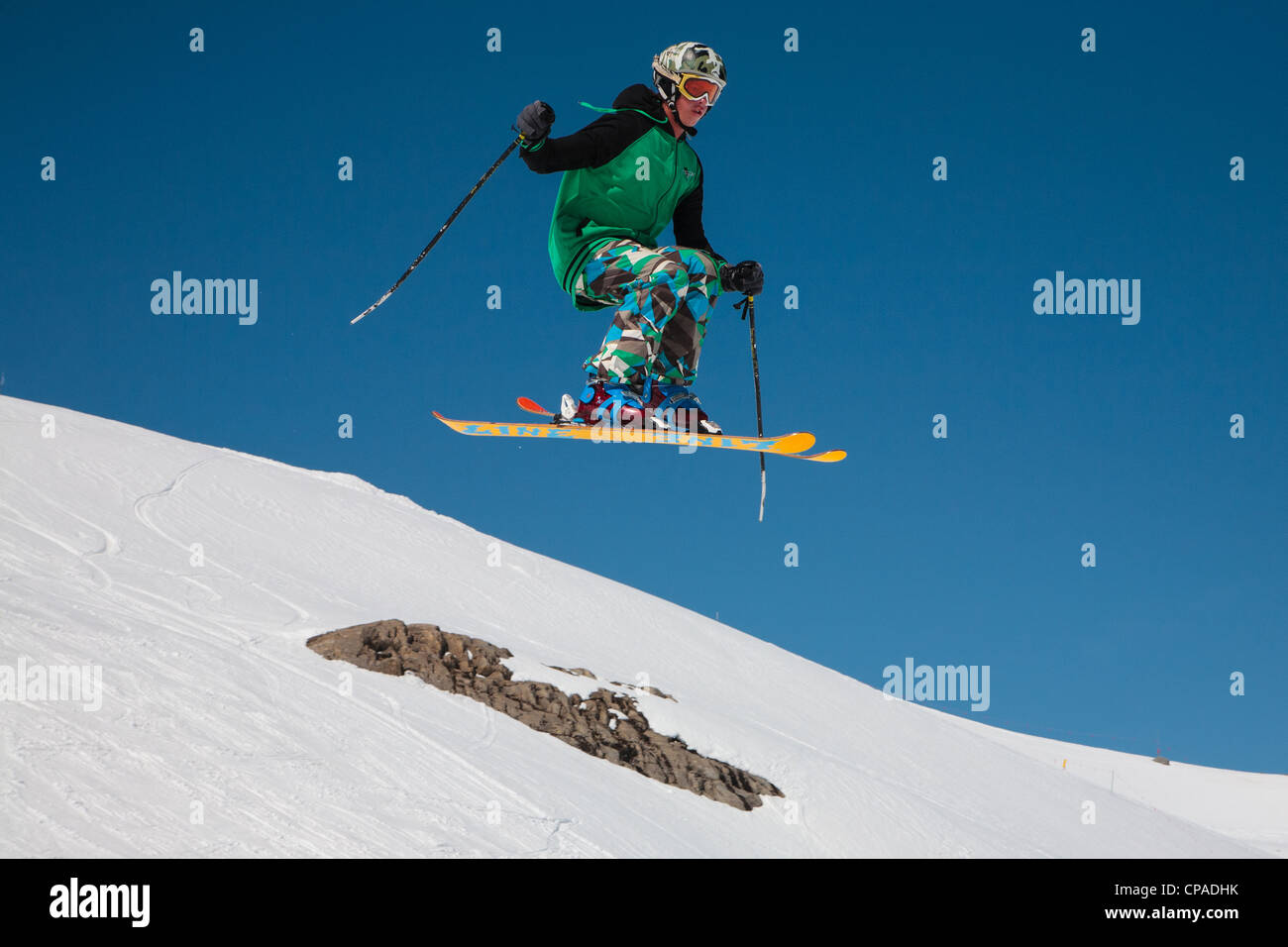 A free-style skier executes a jump against a clear blue sky Stock Photo ...
