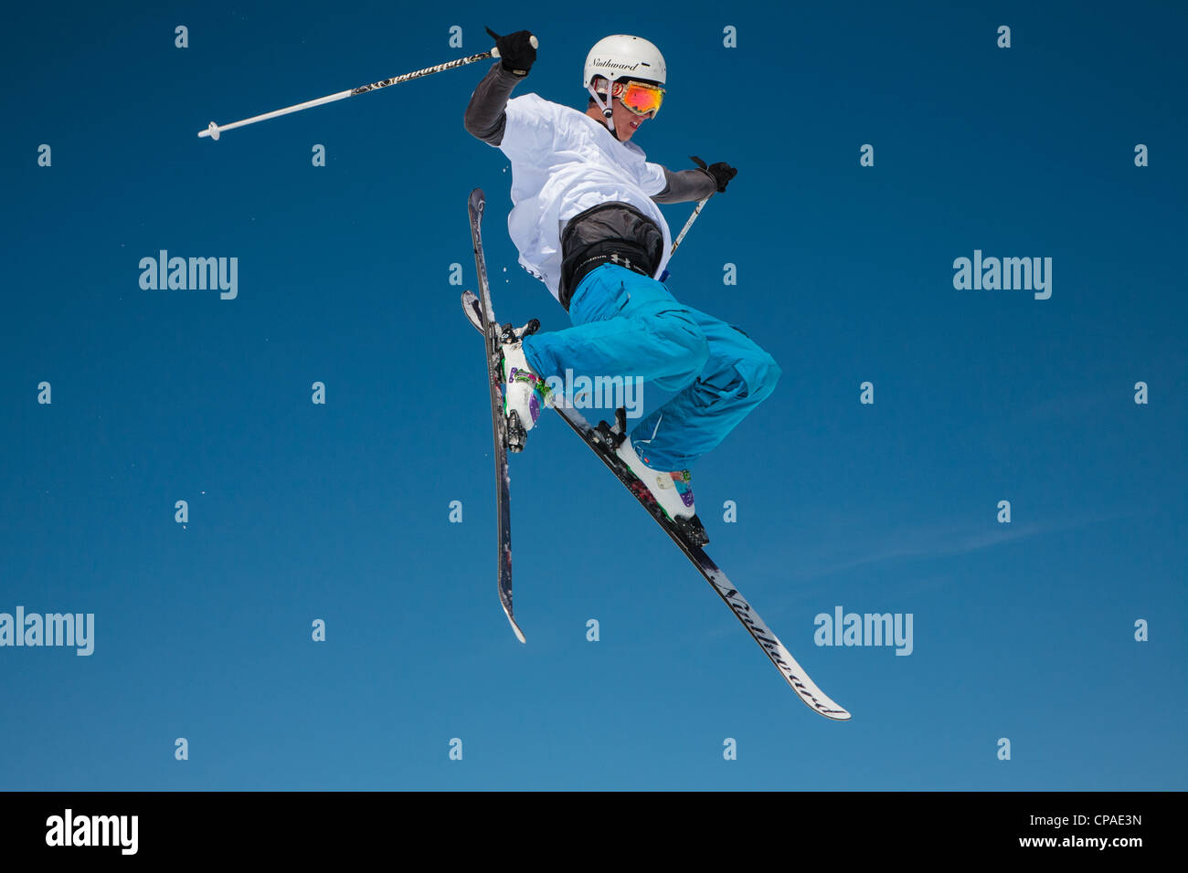 A free-style skier executes a jump against a clear blue sky. 3 of 3 ...