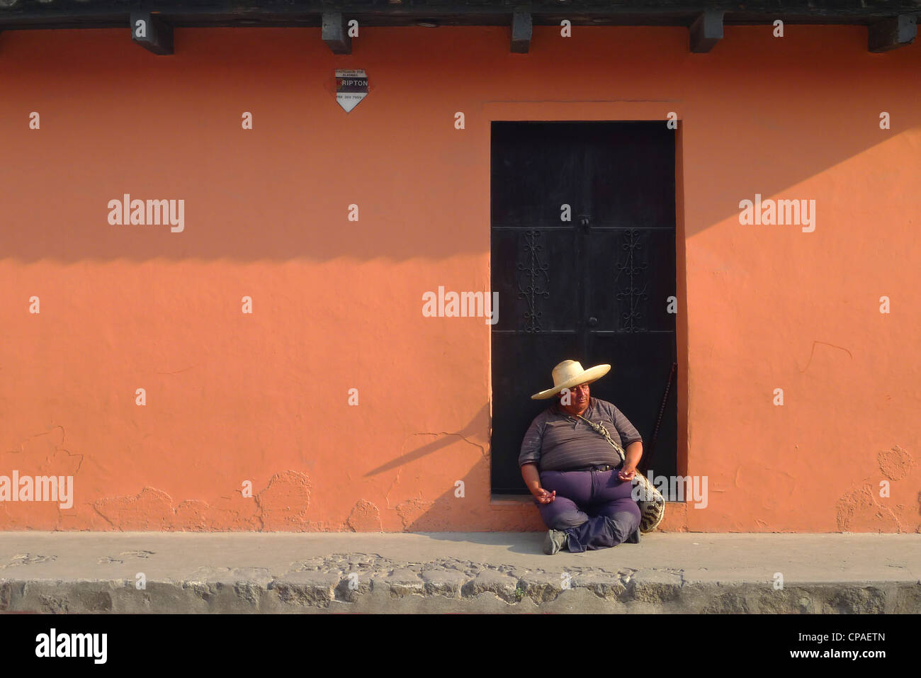 Guatemala Antigua man with sombrero hat sitting by colorful wall cobble ...