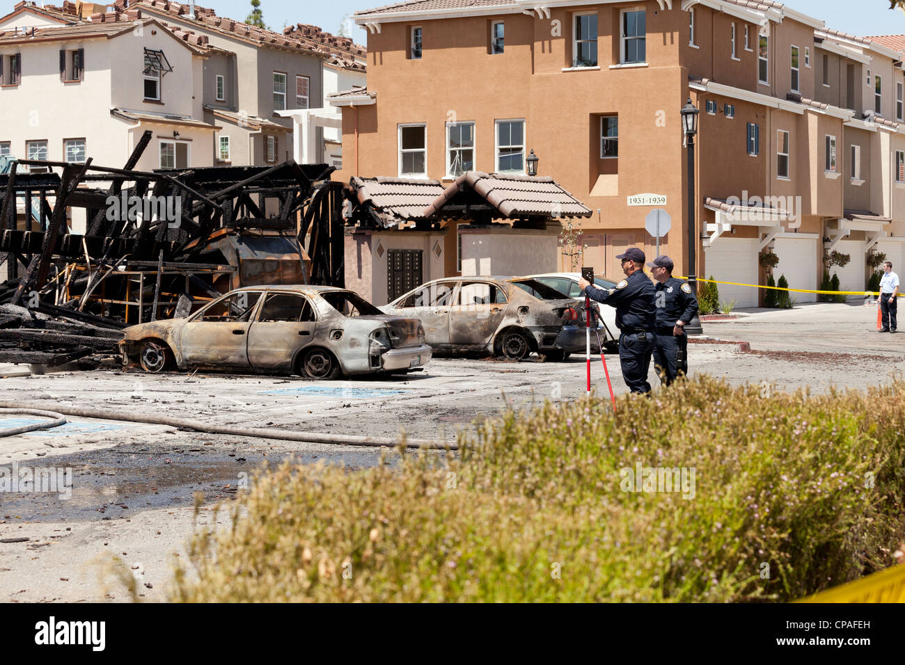 Police and fire officials investigate the aftermath of a fire Stock ...