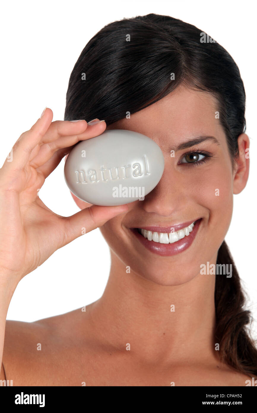 Woman covering eye with pebble Stock Photo - Alamy