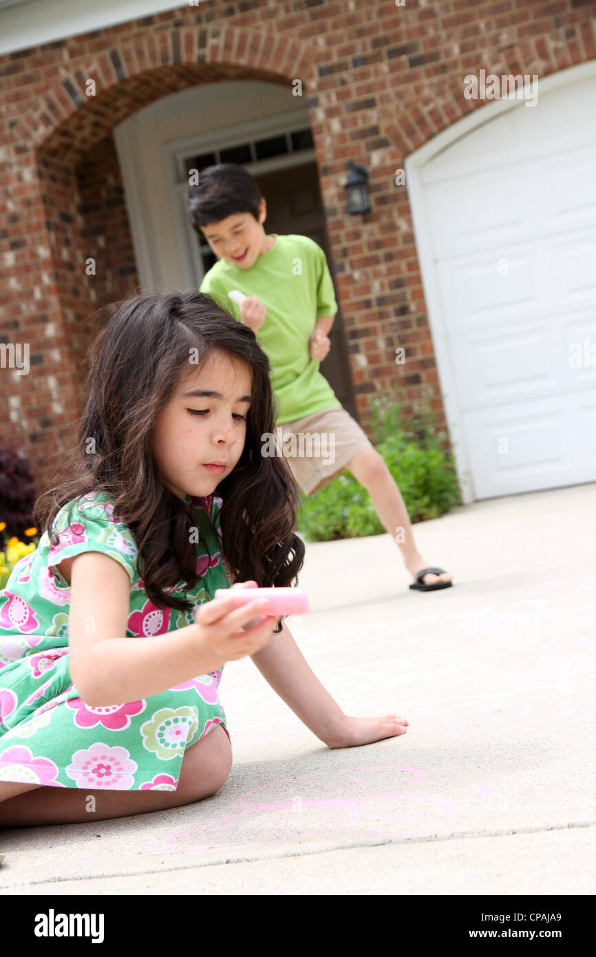 Children playing with chalk in the driveway Stock Photo - Alamy