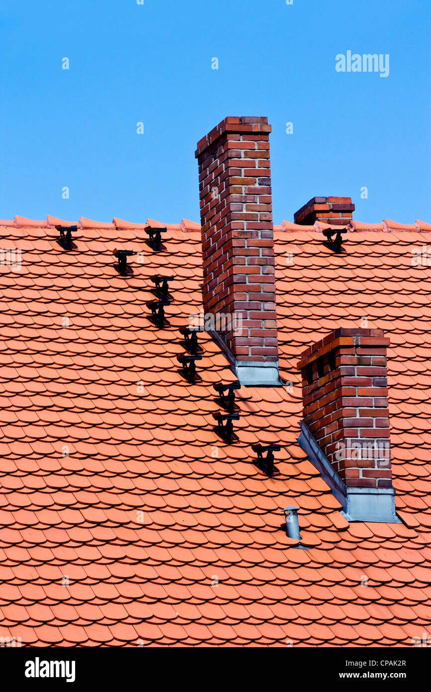 red tiles roof and bricks chimney on blue sky Stock Photo - Alamy