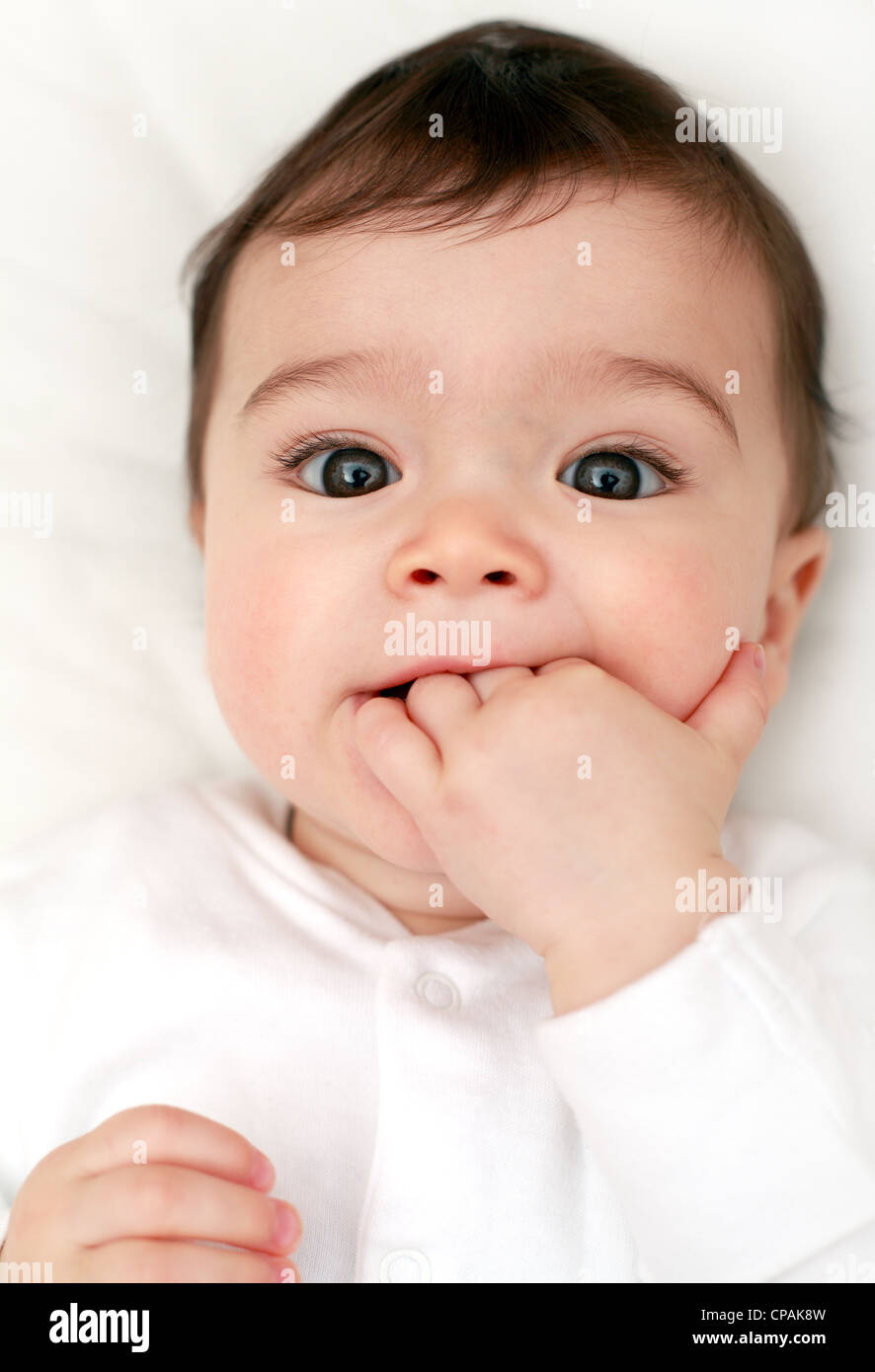 Baby biting on fingers Stock Photo - Alamy