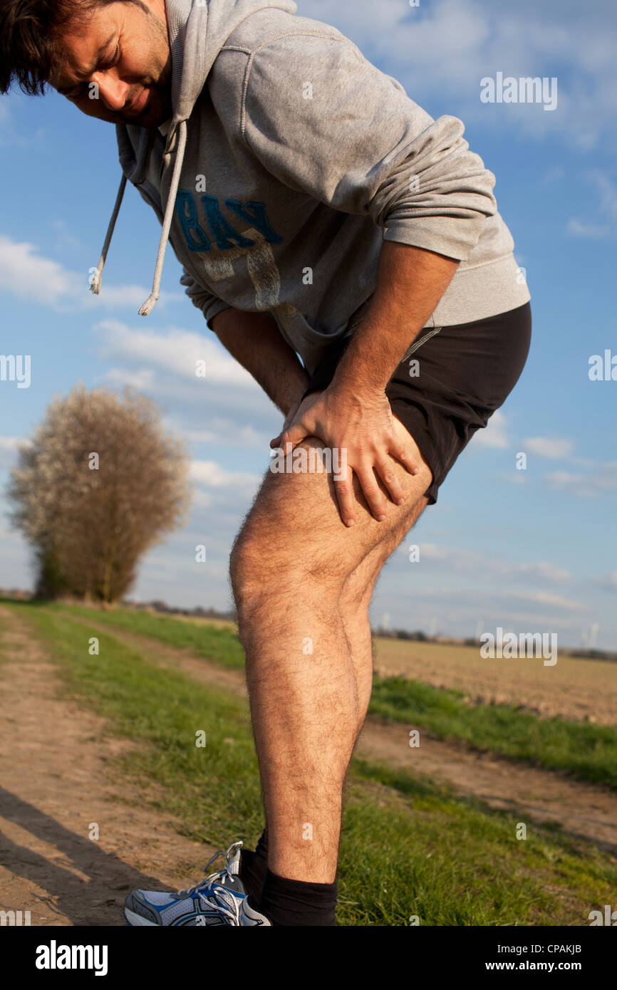 Man having cramp while running Stock Photo - Alamy