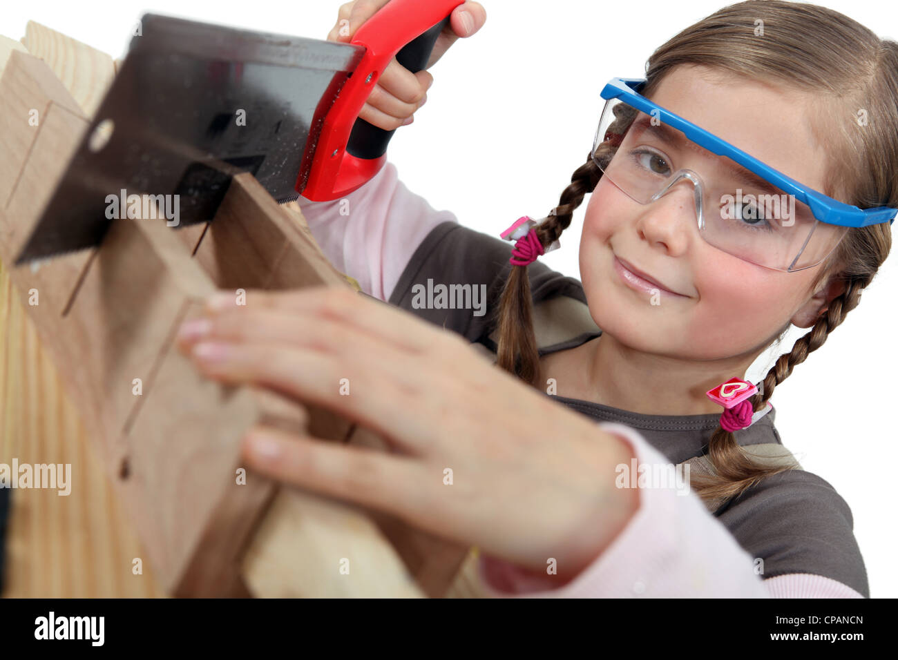 Little girl using a hand saw Stock Photo - Alamy